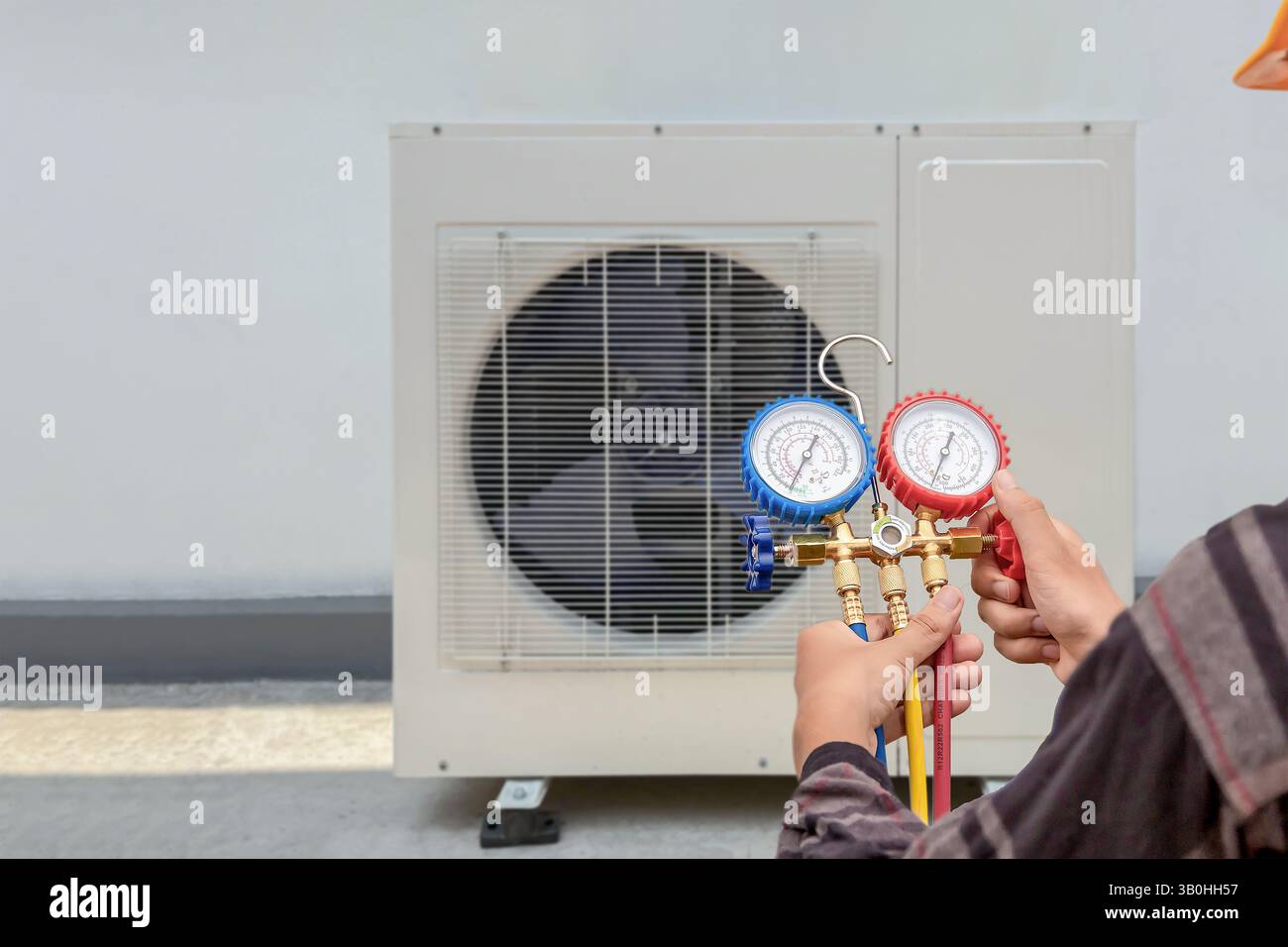 Air conditioning, HVAC service technician using gauges to check ...