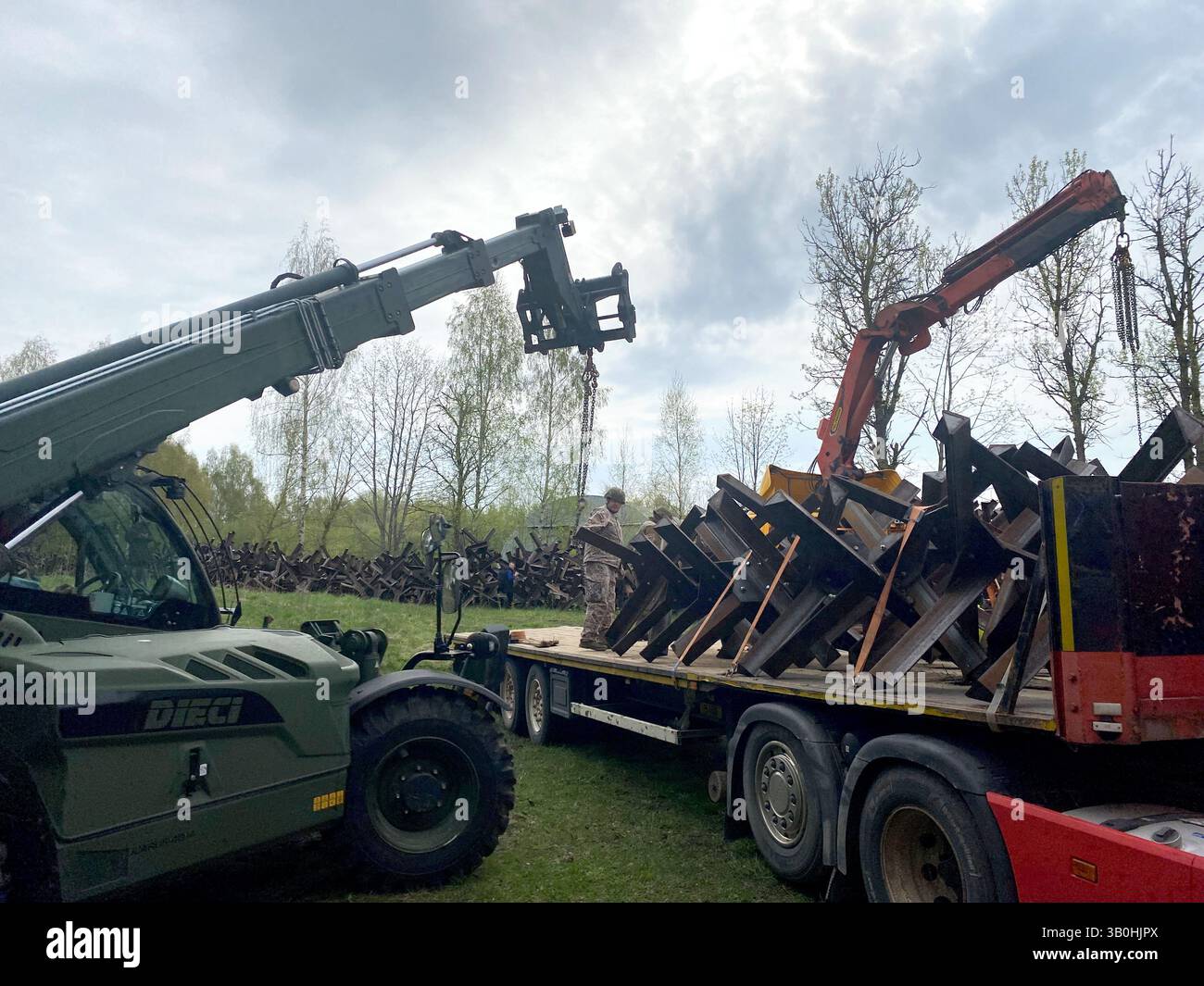 24 April 2025, Latvia, Zilupe: Soldiers load armored barriers onto a ...