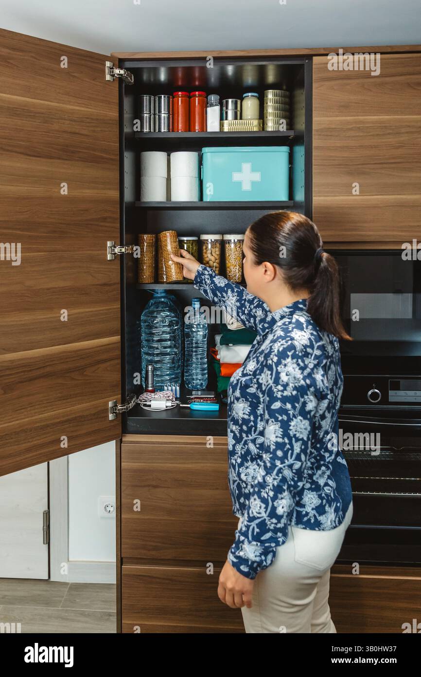Unrecognizable female preparing 72 hours emergency survival kit stored ...