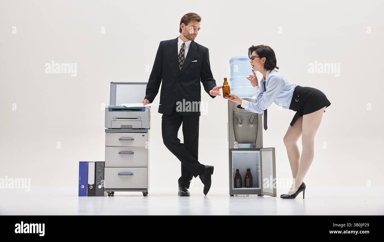 Man receiving bottle from colleague at water cooler while holding ...