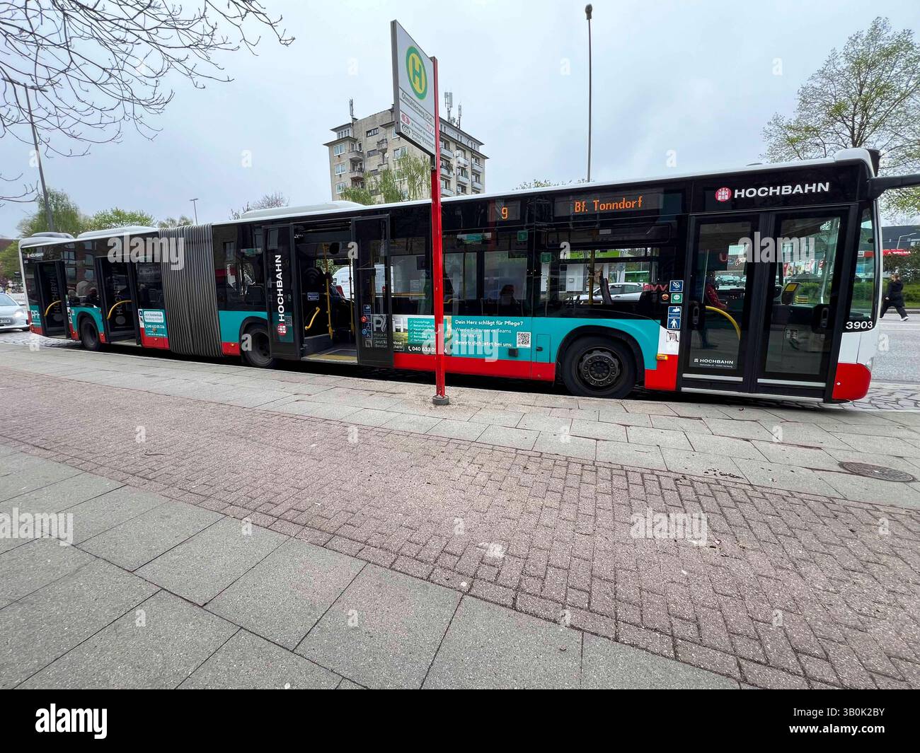 21 meter langer Gelenkbuss der LIne 9 steht an einer HVV Bushaltestelle ...