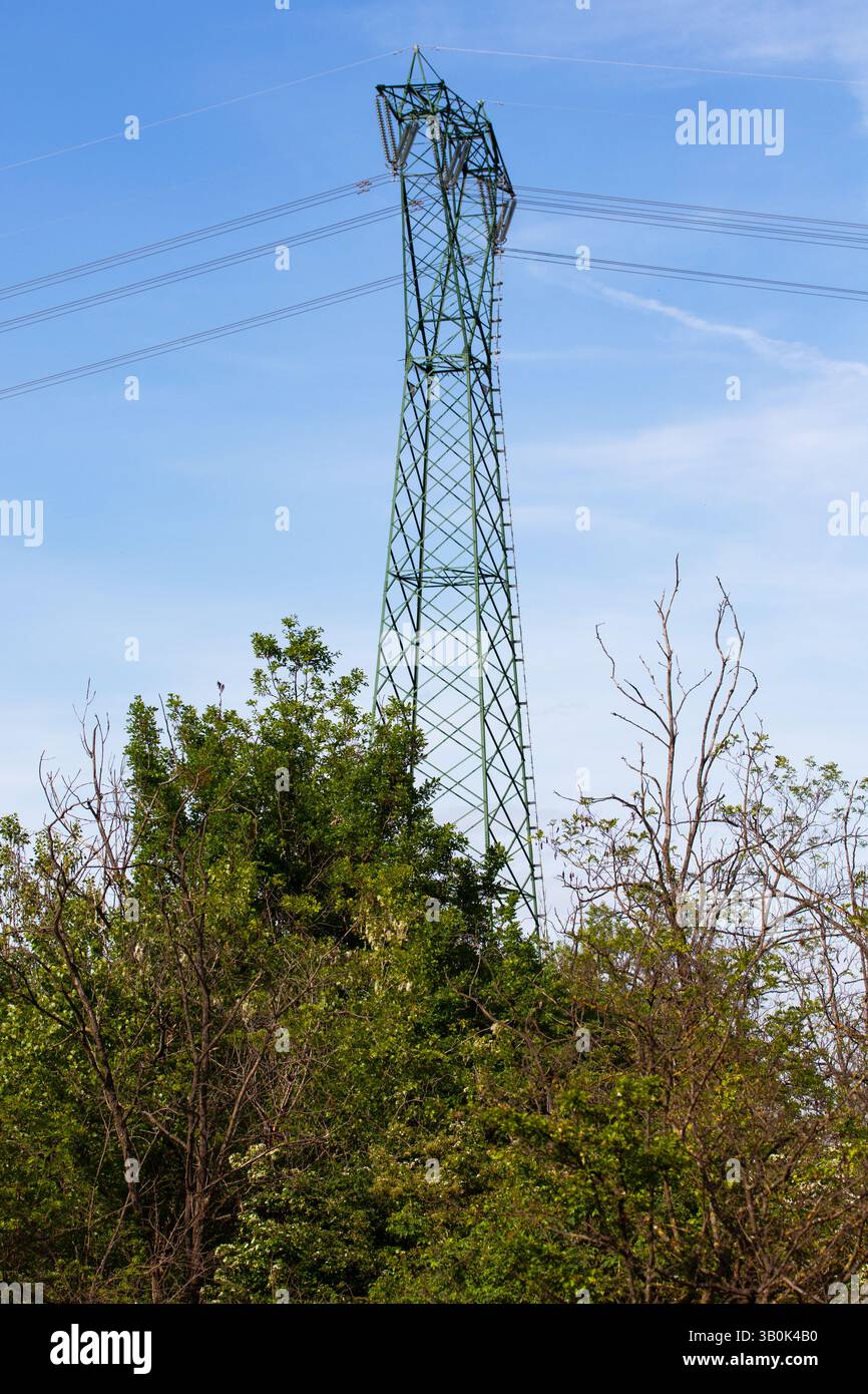 Tall electricity pylon stands against blue sky power lines stretch ...