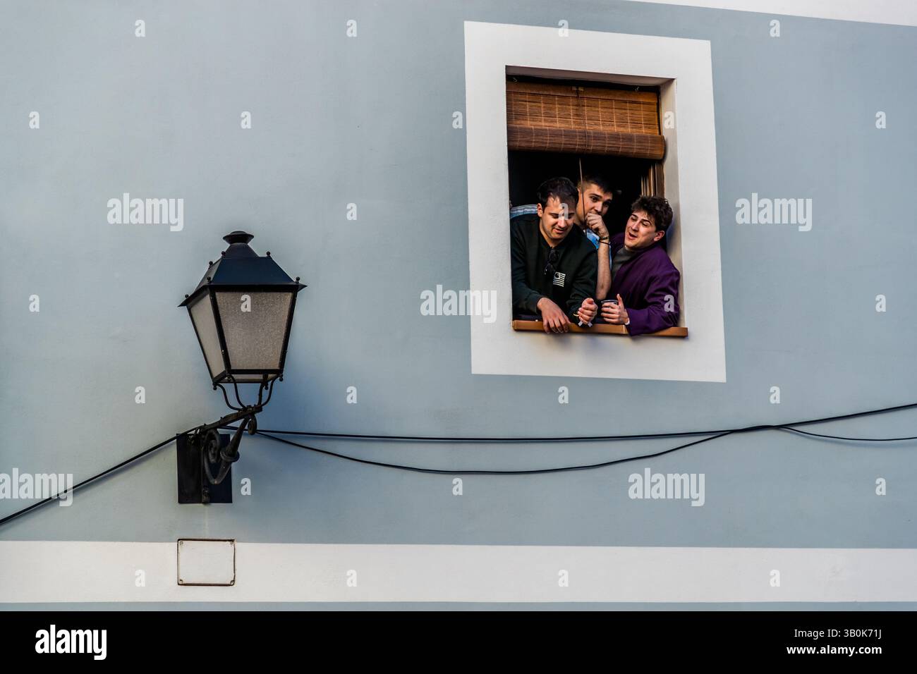 Three young men look out of a window in Spain.. Plaza Salvador, Cuenca ...