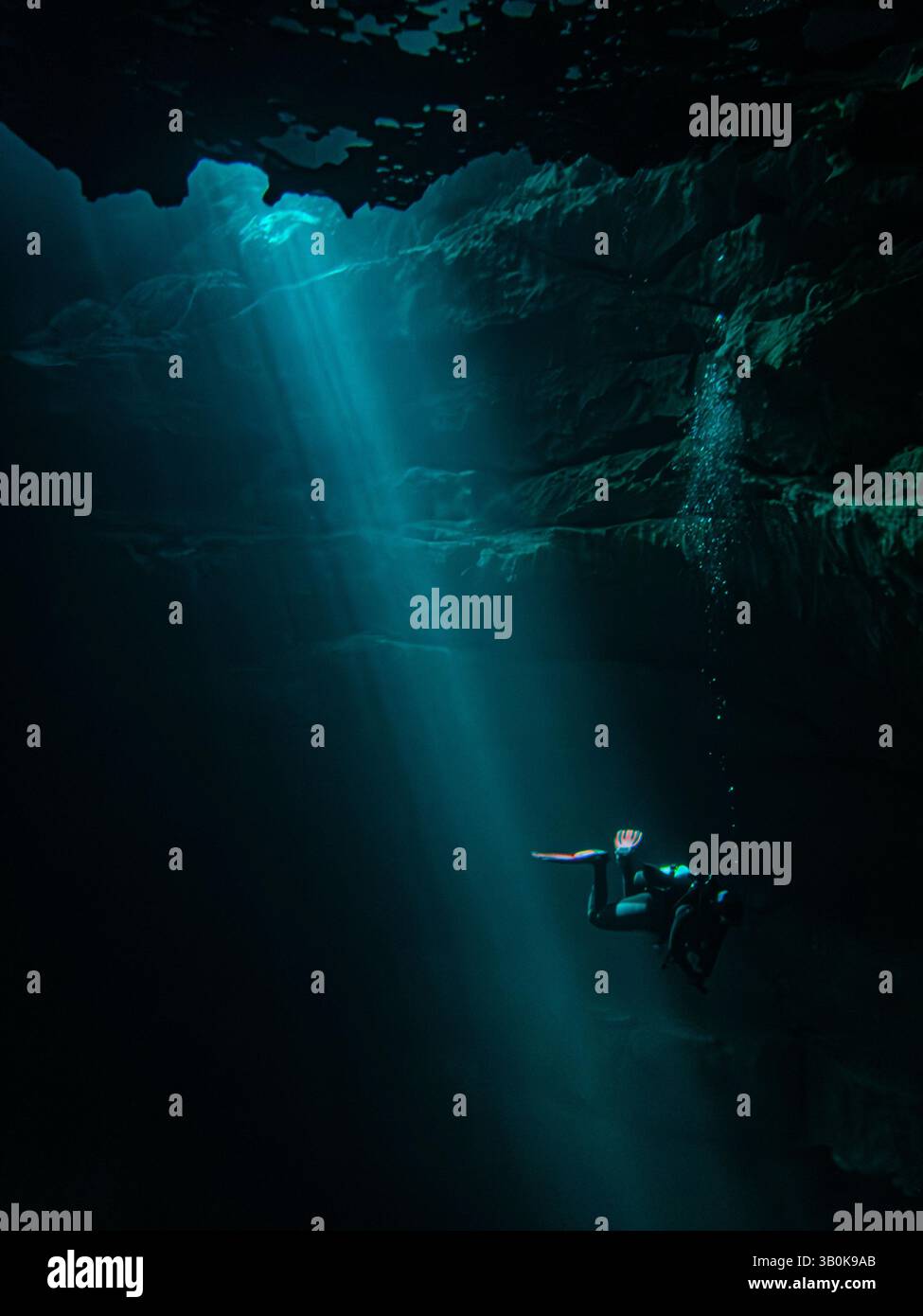 Diver caught in a beam of light in the underwater cavern at Buford Sink ...