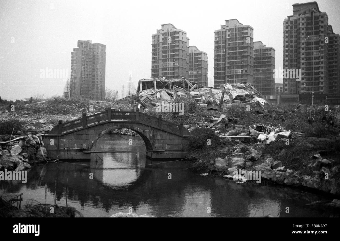Reflective Stone Arch Bridge amid Demolition Debris and High-Rise ...