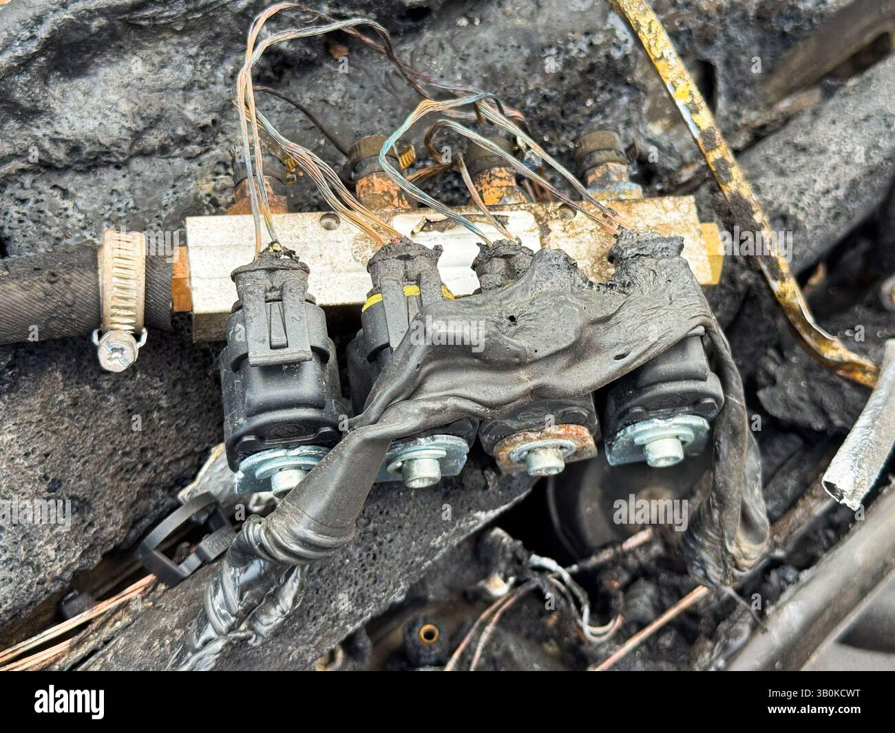 Burned fuel injector rail with connectors from a car engine, showing ...