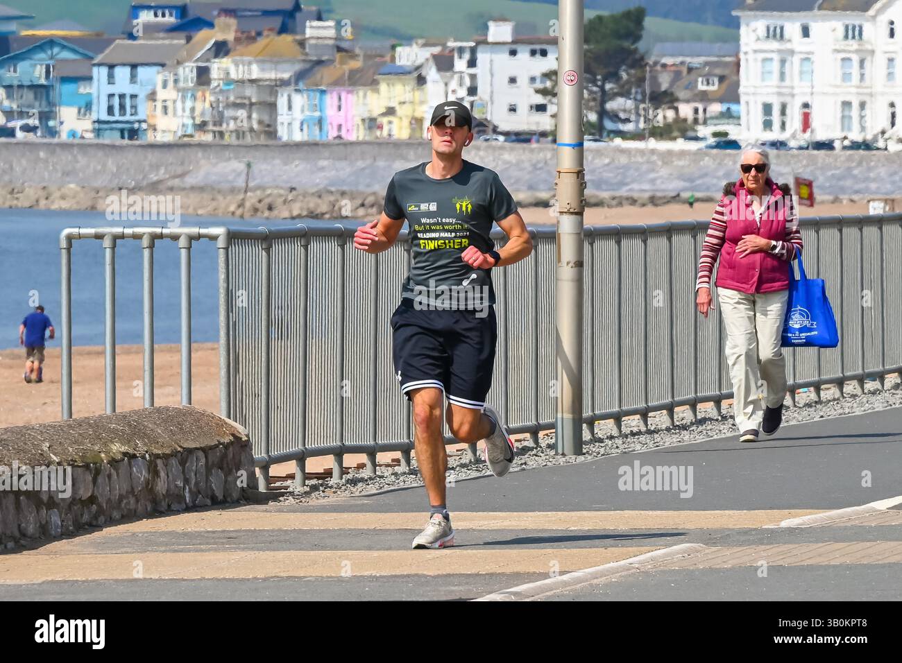 Exmouth, Devon, UK. 24th April 2025. UK Weather: A jogger on the ...