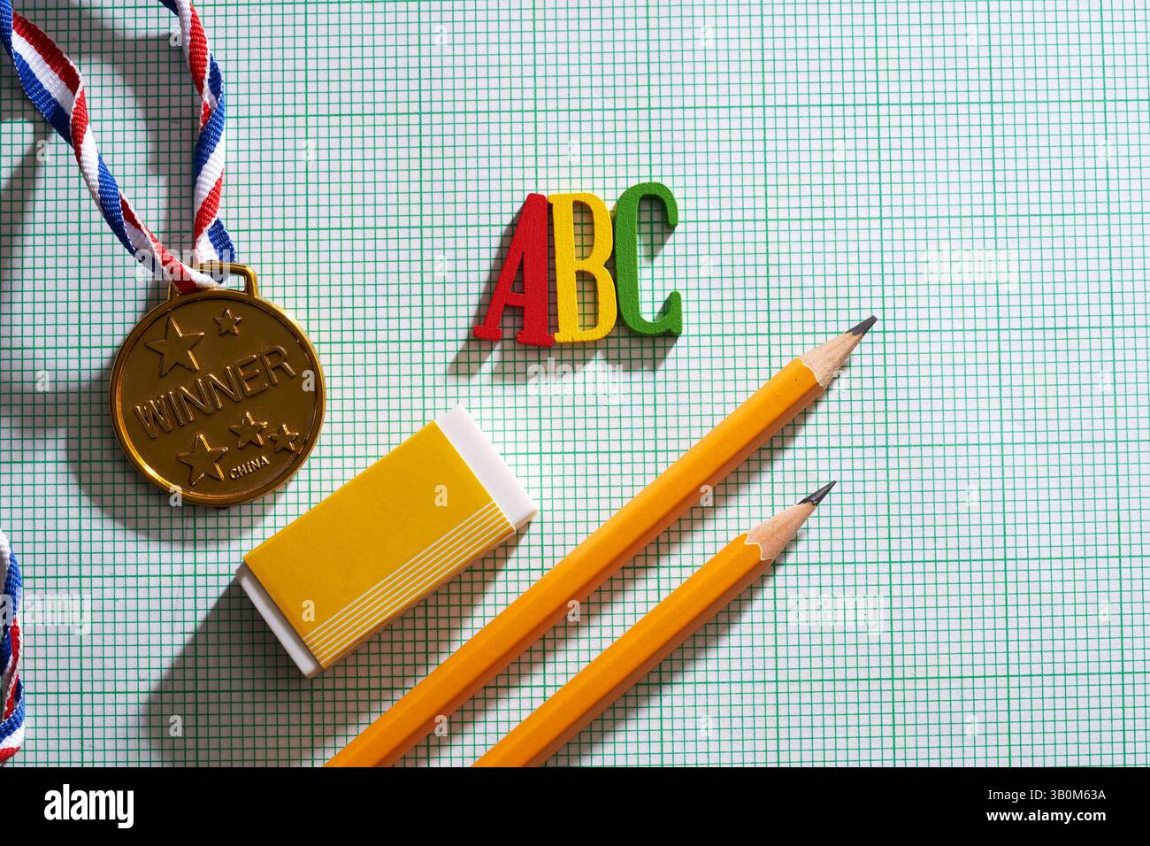 gold medal with ribbon alphabet abc and pencils on graph paper Stock ...