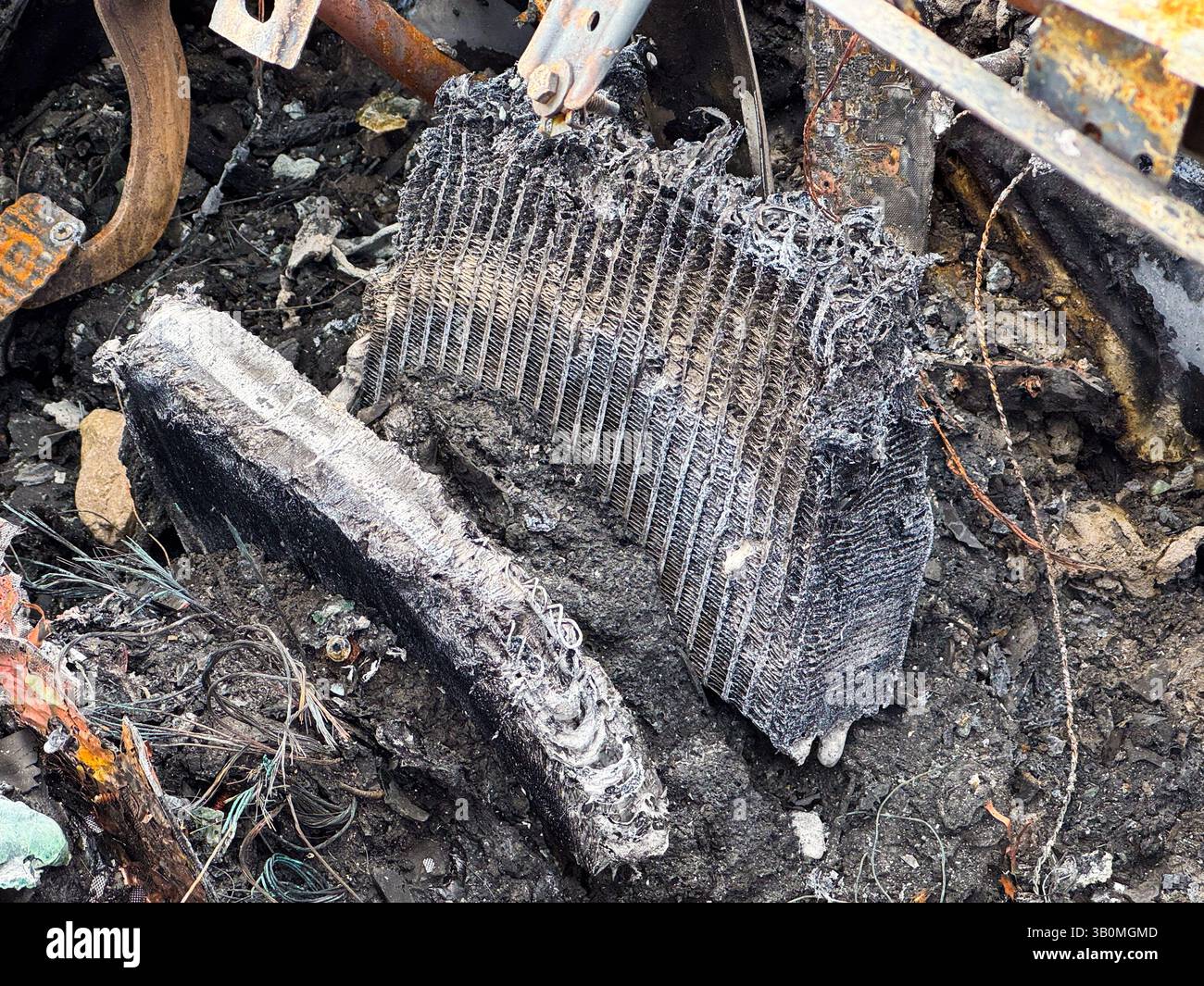 Burned heater core from a car showing severe fire damage, melted fins ...