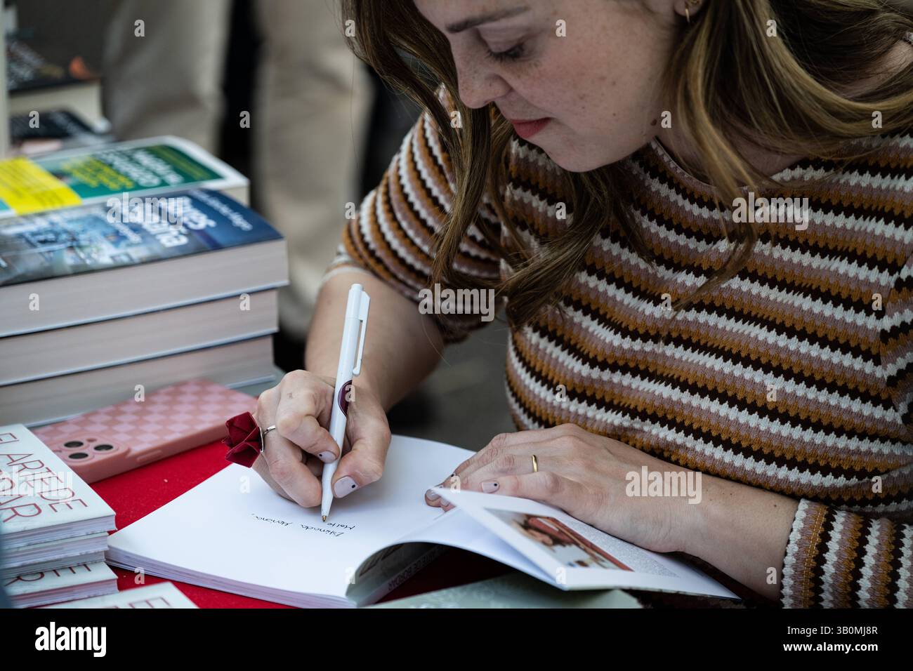 Sant Jordi festival in Barcelona A woman writes in a book as part of ...