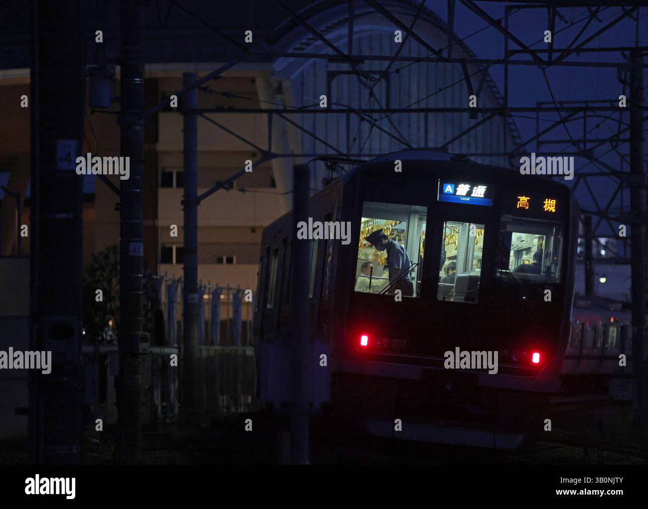 A train passes by the memorial monument erected at the site of the Amagasaki JR derailment ...