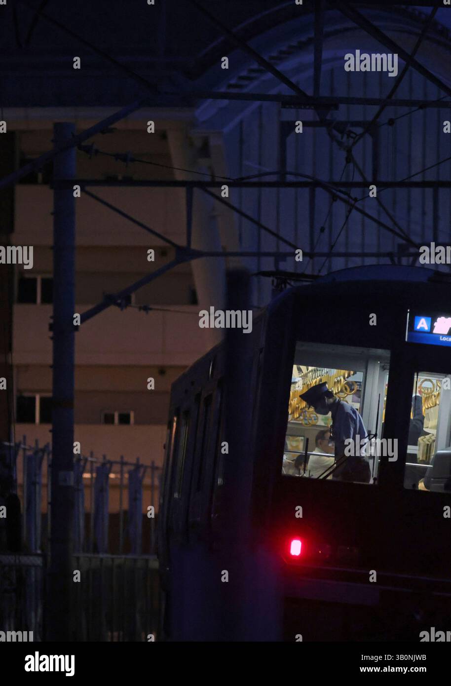 A train passes by the memorial monument erected at the site of the Amagasaki JR derailment ...