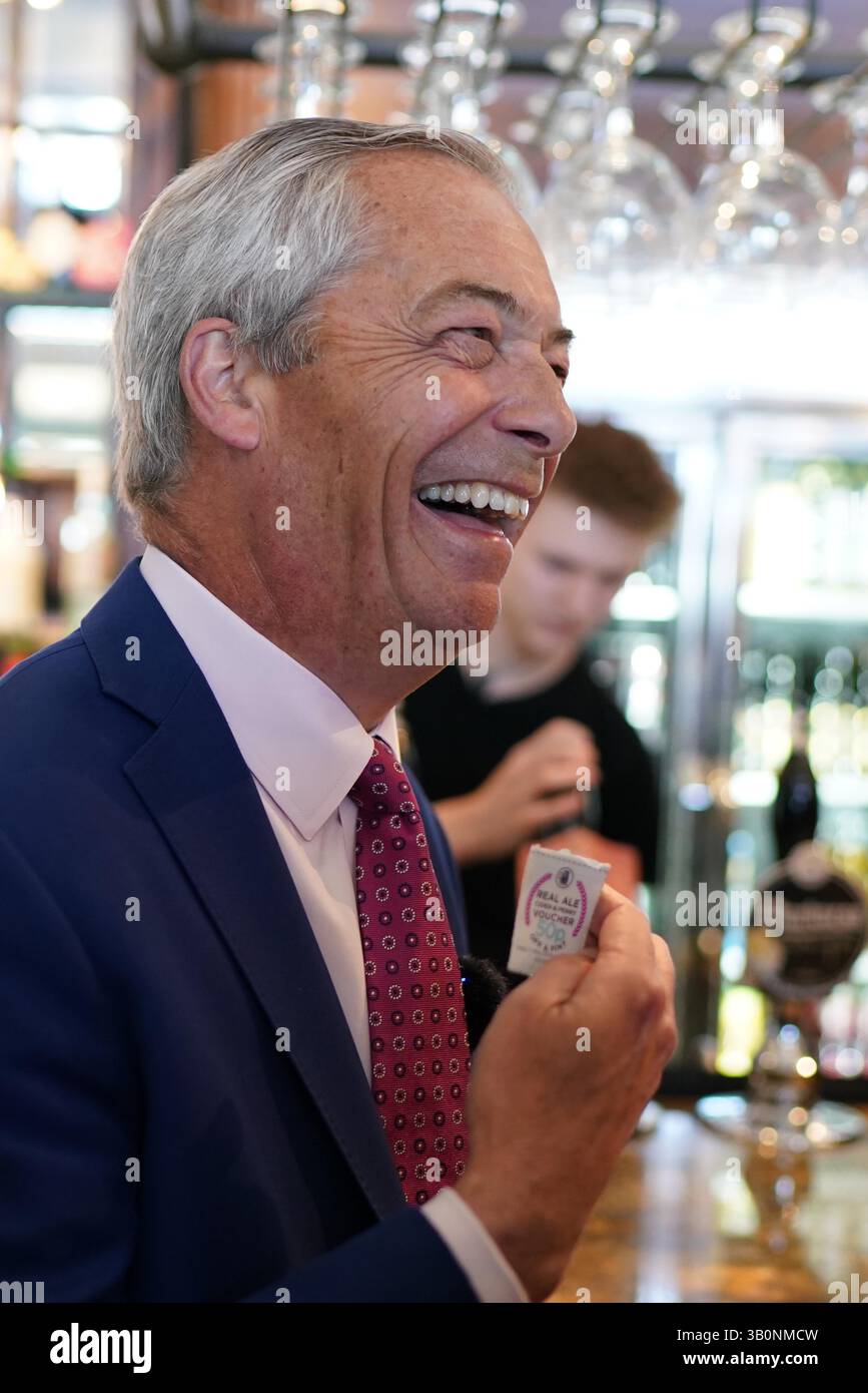 Reform UK leader Nigel Farage has a drink during a visit to the ...