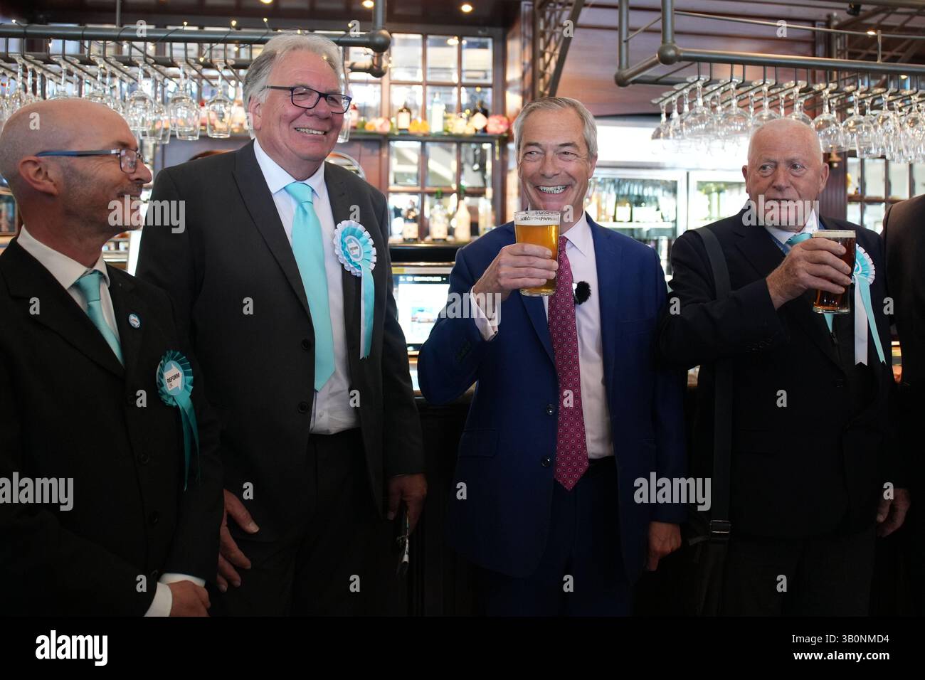 Reform UK leader Nigel Farage (2nd right) has a drink during a visit to ...