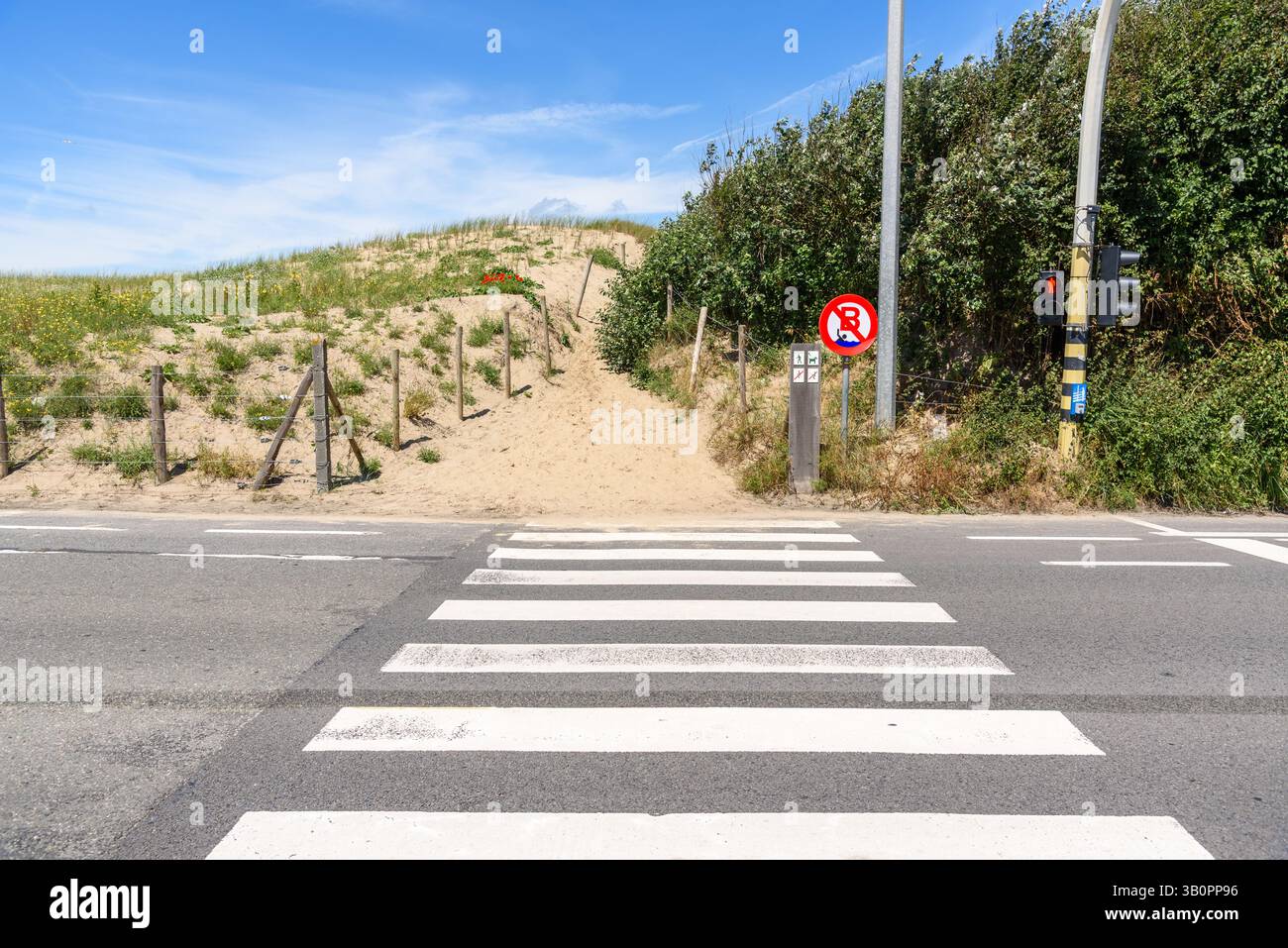 Pedestrian crossing leading to a sandy footpath running through sand ...