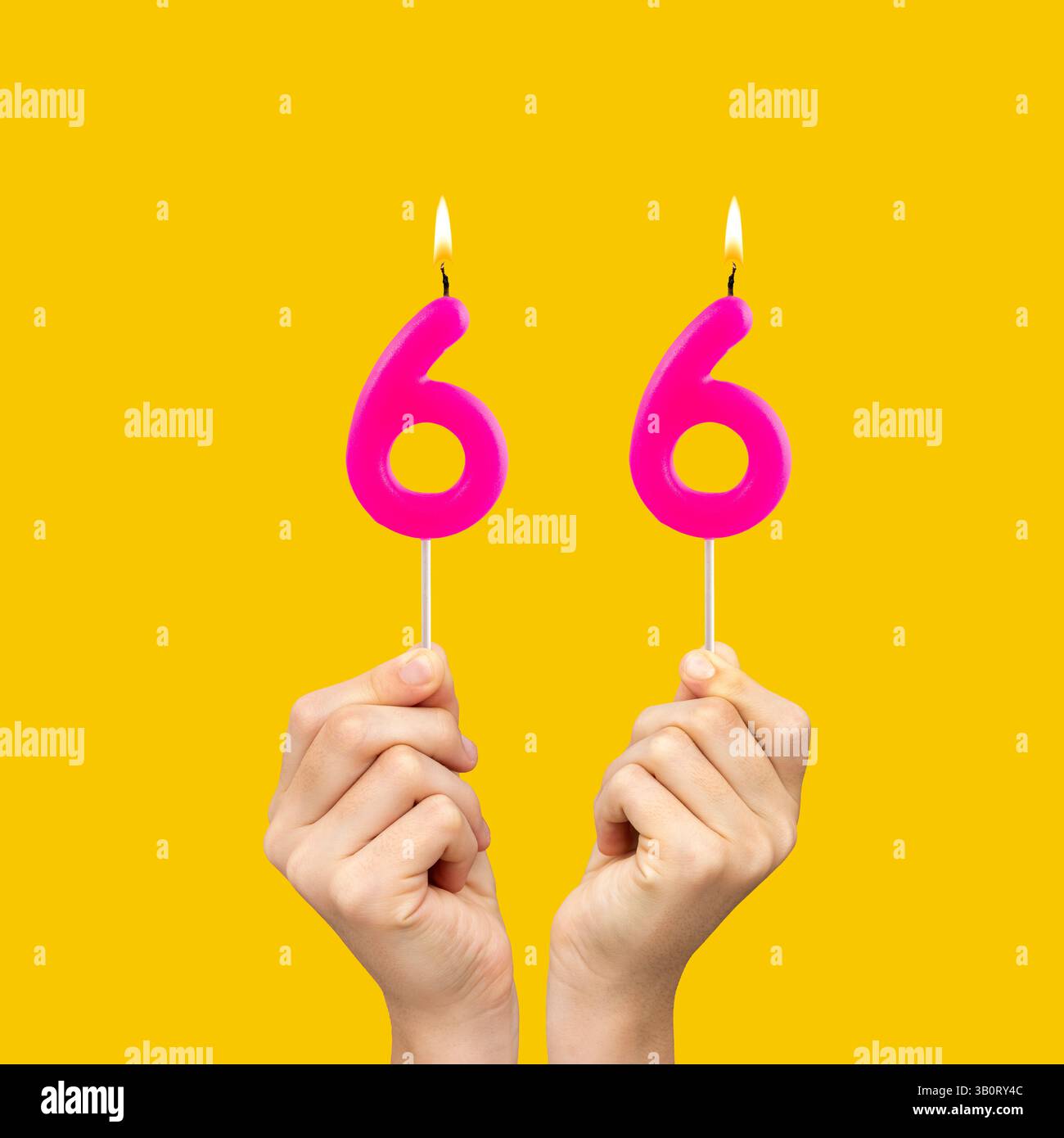 Hands holding birthday candles with number 66 - Yellow background Stock ...