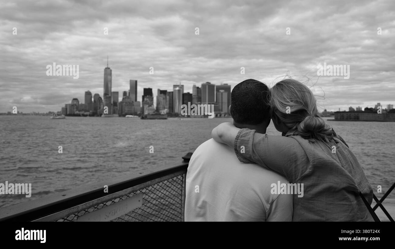 Couple in love looking Manhattan skyline New York Downtown landscape in dramatic black and white ...