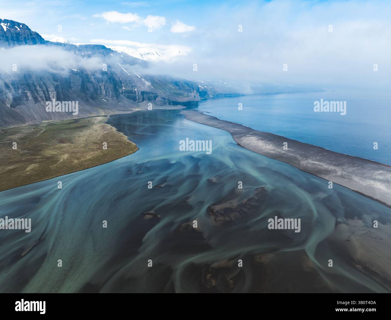 Aerial view of glacial river delta flowing into the sea, with surreal ...