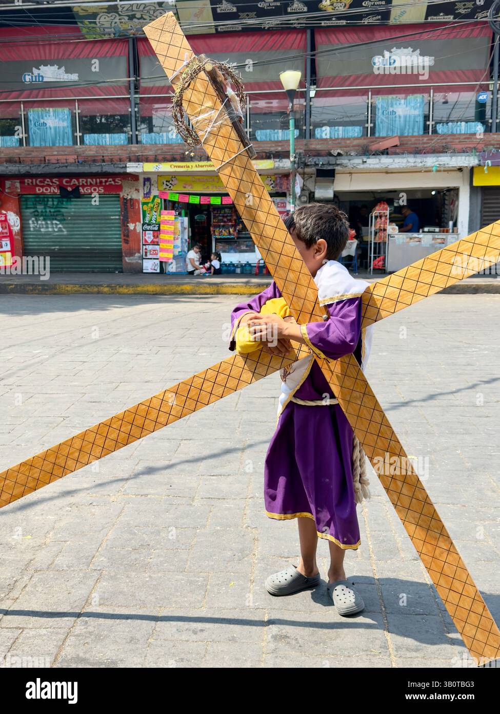 On Holy Friday in Iztapalapa, faithful child carry large wooden cross ...