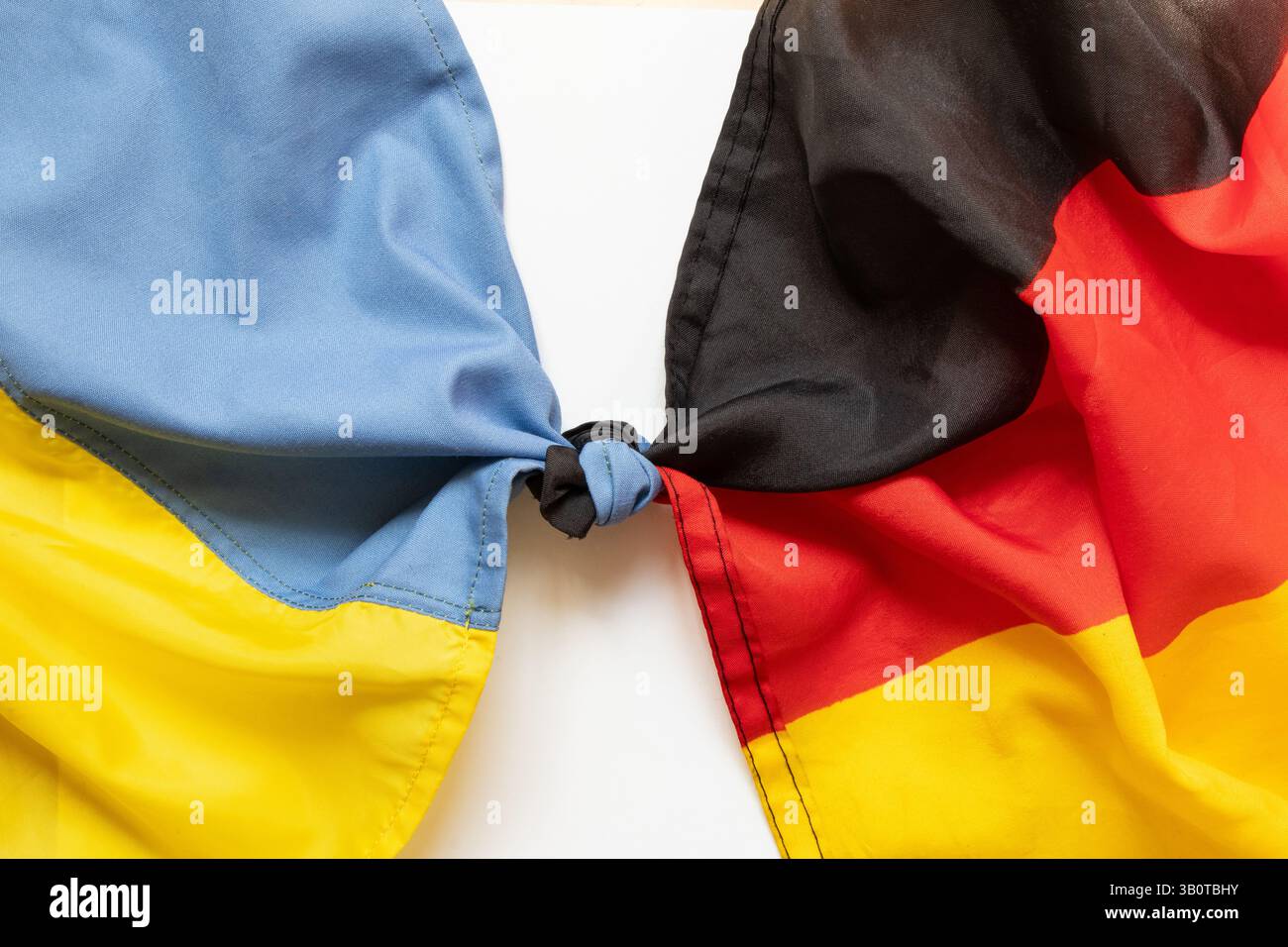 The flags of Germany and Ukraine are tied in a knot, symbolizing the ...