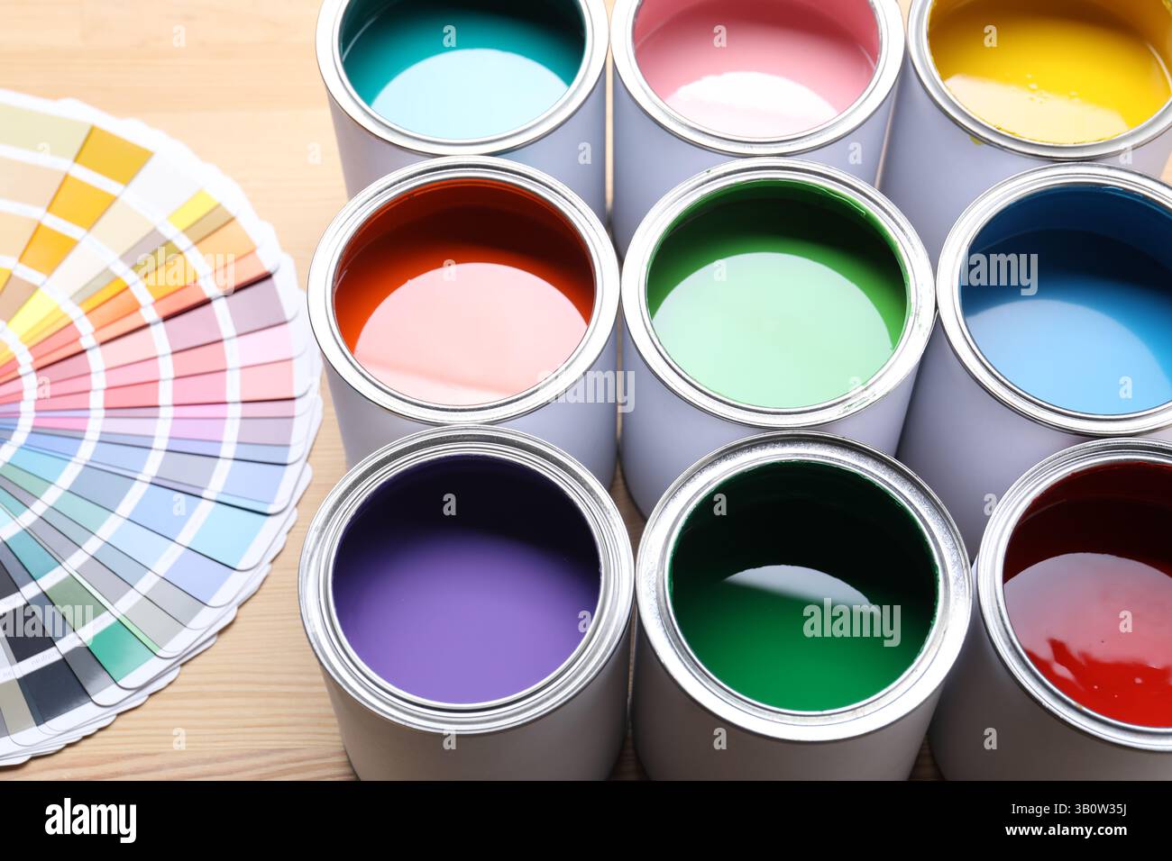 Cans of bright paints and color palettes on wooden table, closeup Stock ...