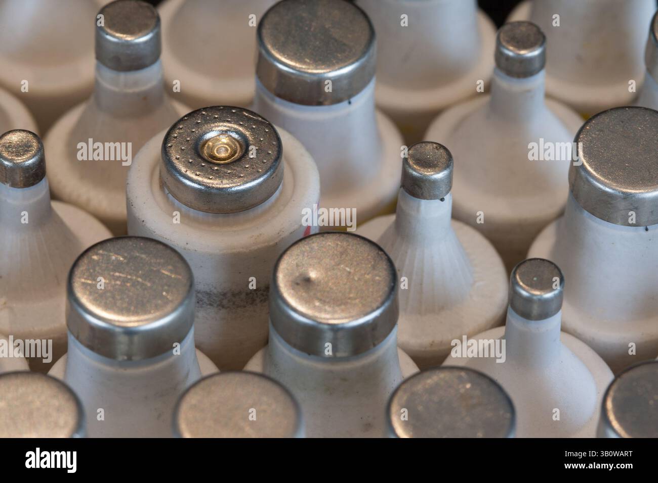 Close-up of old screw-in fuses. One stands out because it's upside down ...