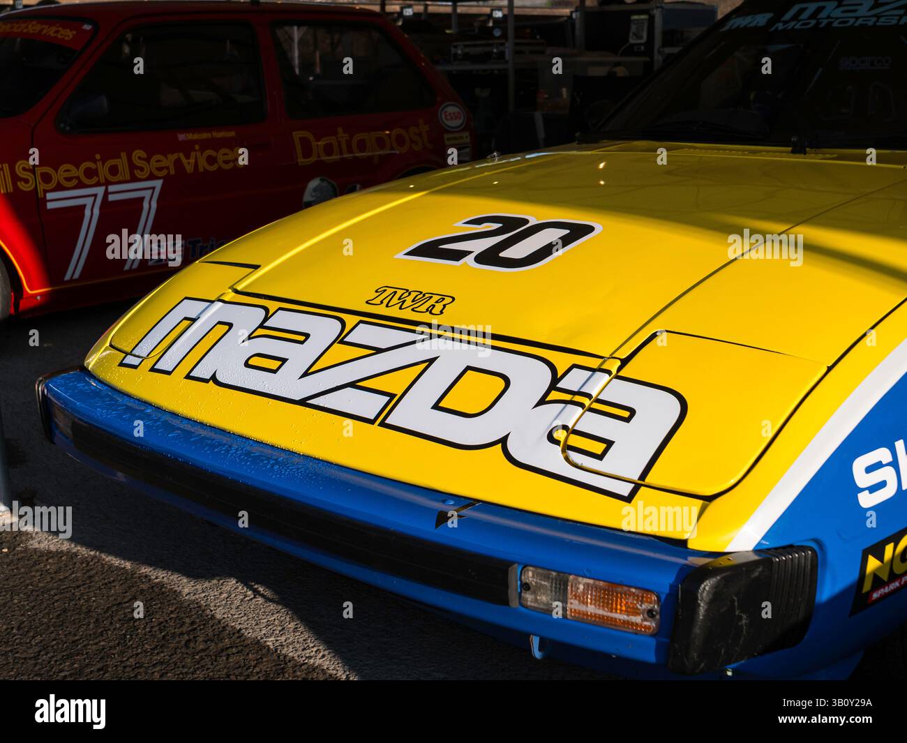 Close up of a yellow 1980 Mazda RX7 saloon racing car, 82 Members Meeting, Goodwood Motor ...
