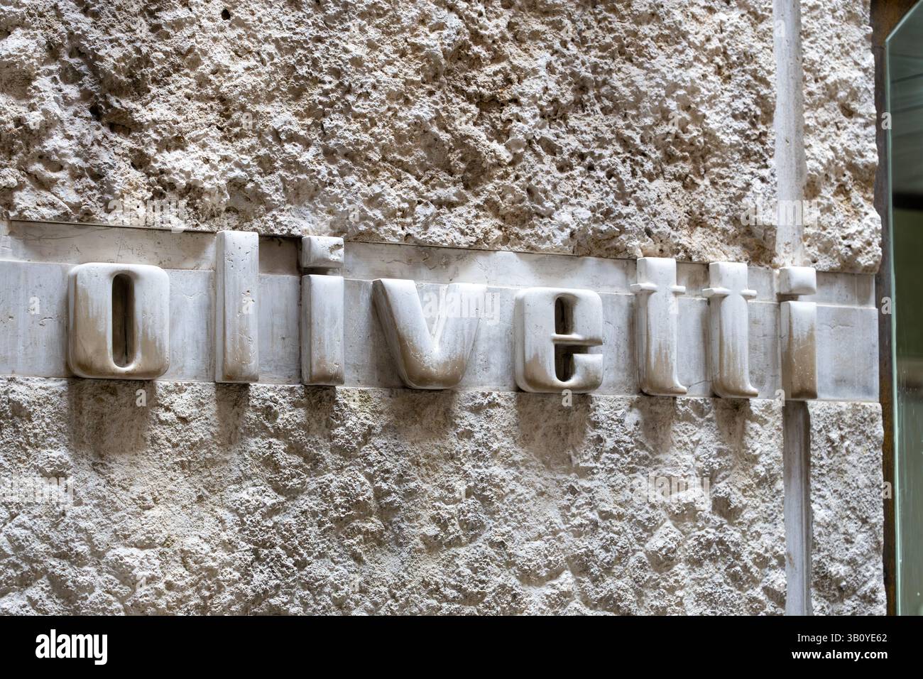 Venice, Italy - April 17 2025: Stone Olivetti sign embedded in historic ...