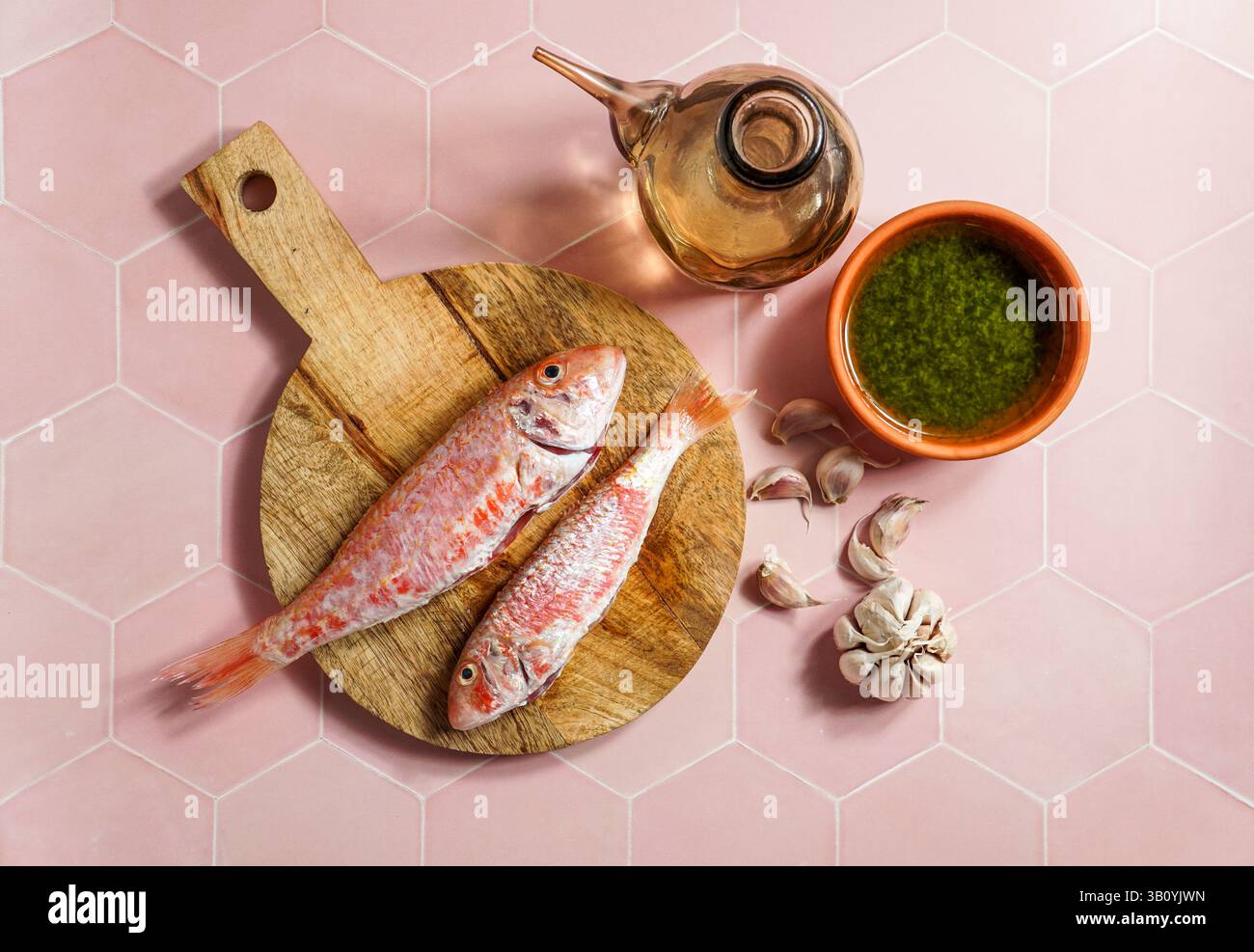 resh red mullets on a rustic wooden cutting board with olive oil ...