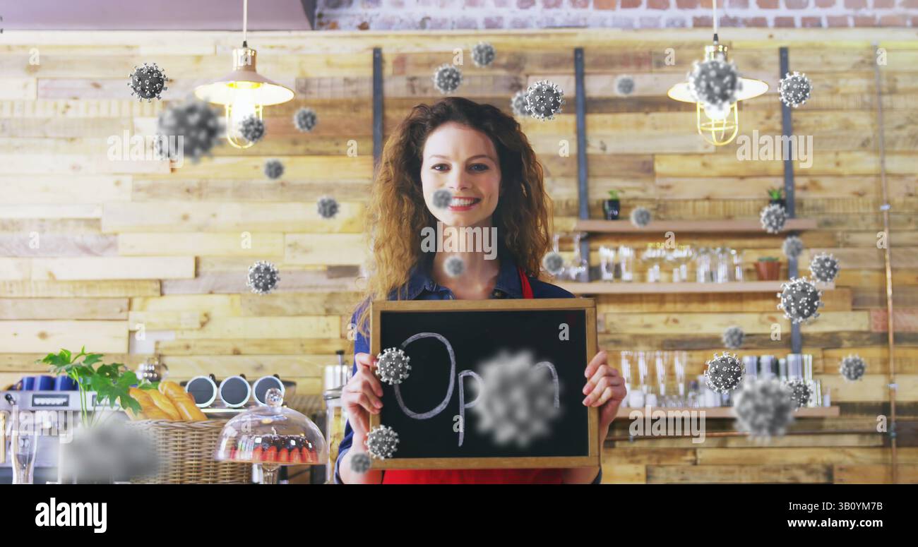 Mid-adult barista holding chalkboard sign at cafe counter, with ...