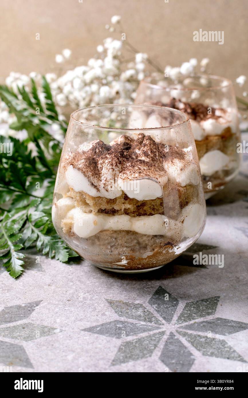 Classic Italian tiramisu in two glasses. Layers of sponge cake and ...