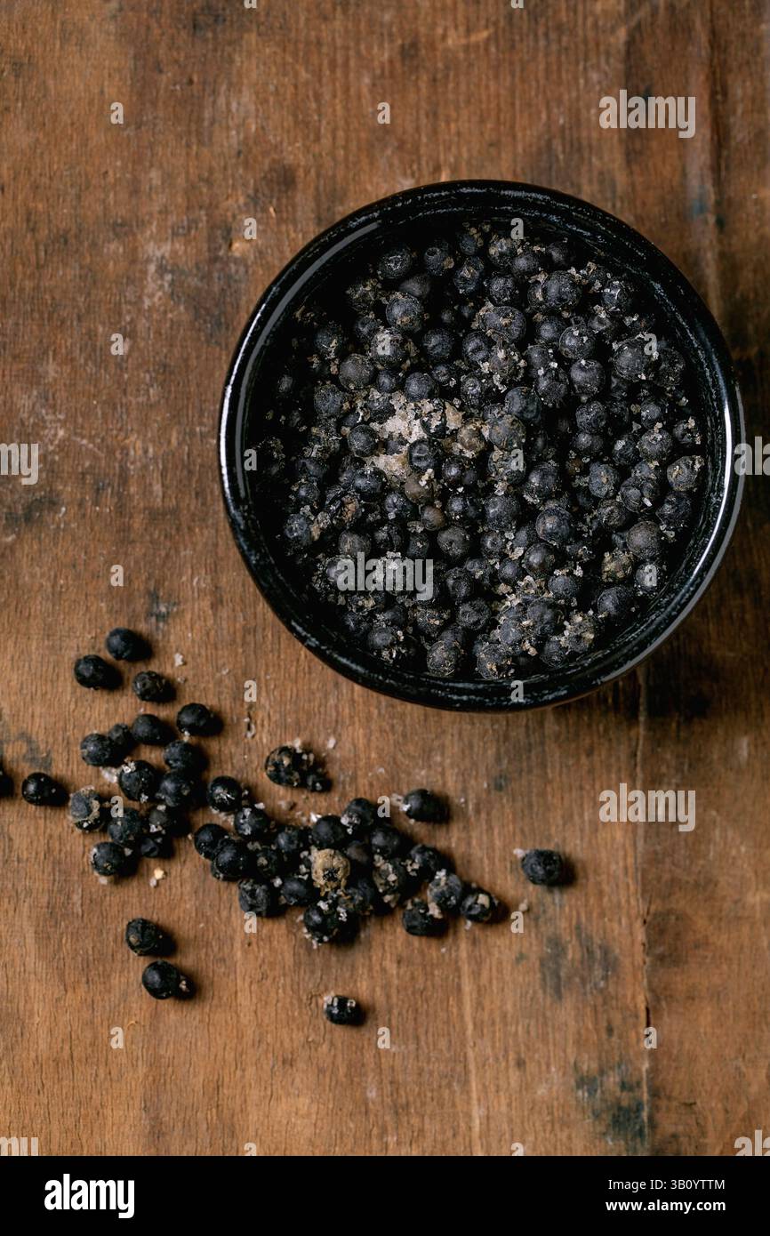 Black salted fermenter Campota pepper in black ceramic bowl on dark ...