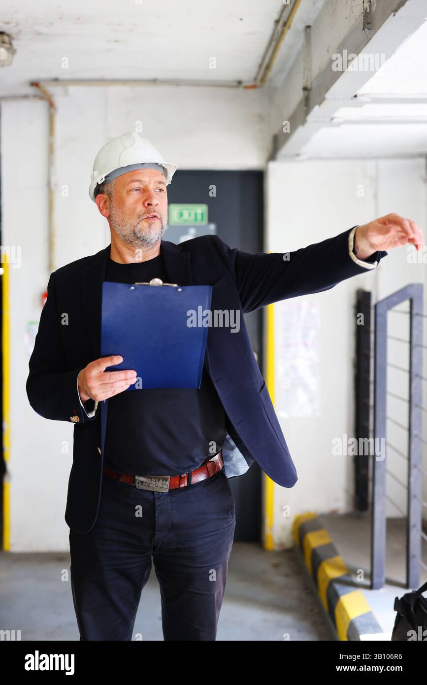 Construction executive in safety helmet speaking to team during ...