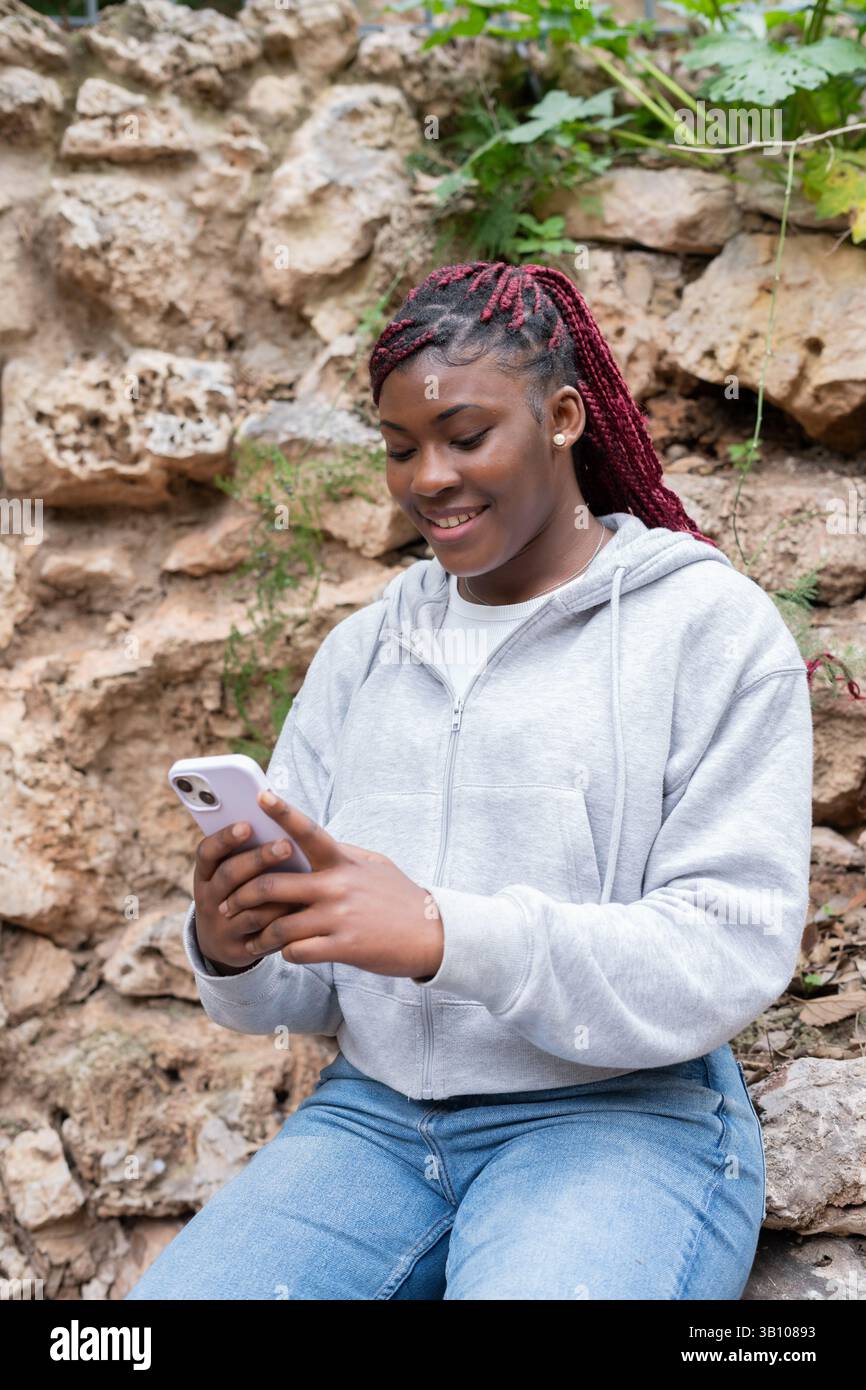 Woman braids browsing phone hi-res stock photography and images - Alamy