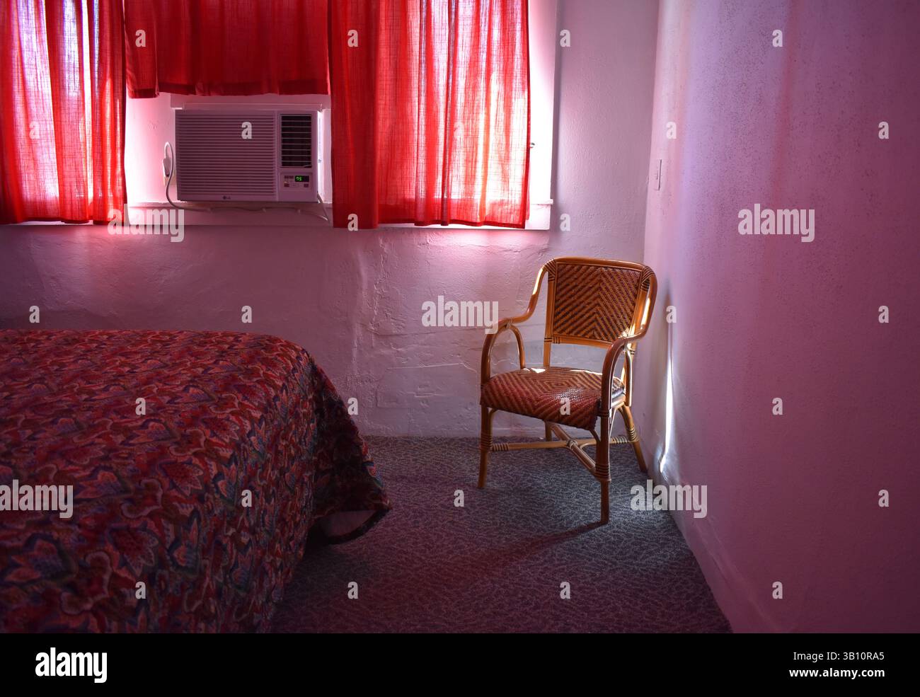Wicker chair in a cozy motel room interior with soft light from the ...