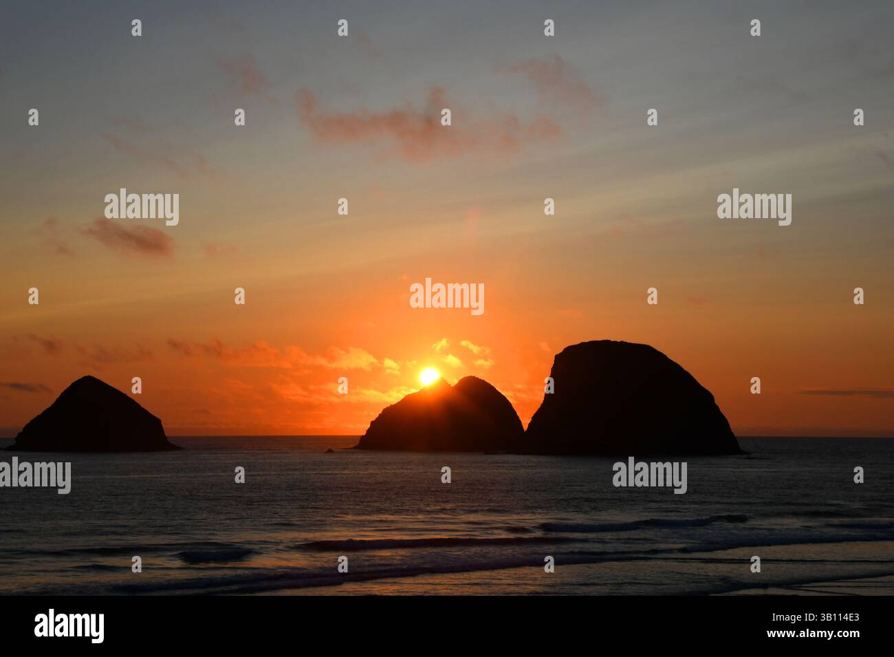 Sun sets as a ball of fire behind sea stacks at Oceanside, Oregon ...
