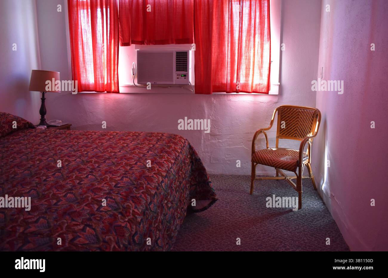 Wicker chair in a cozy motel room interior with soft light from the ...