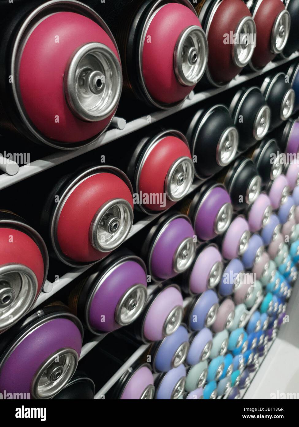 Rows of maroon, purple and violet spray cans on shelves. Hardware store ...
