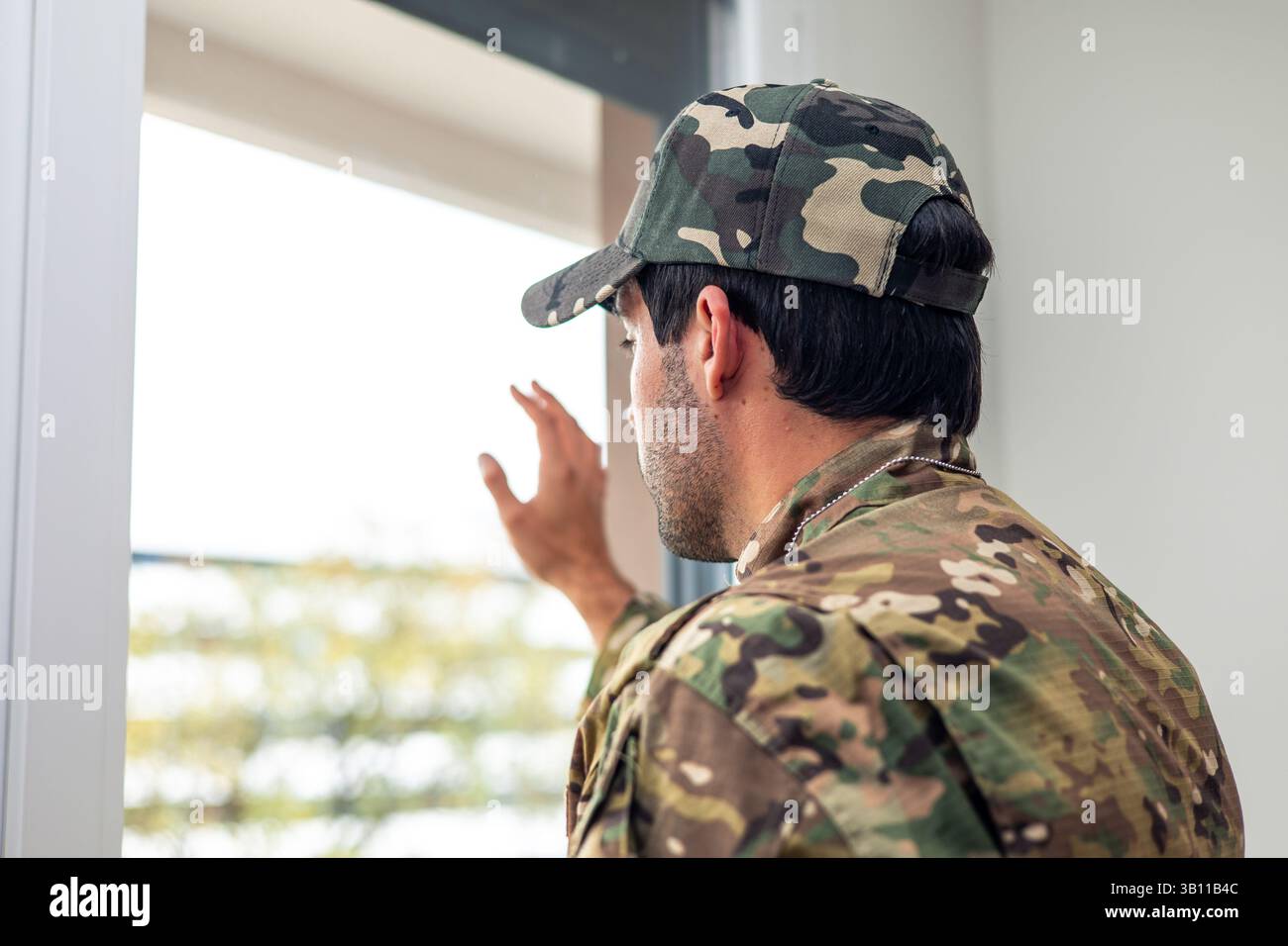 Young soldier wearing camouflage cap and uniform suffering from post ...