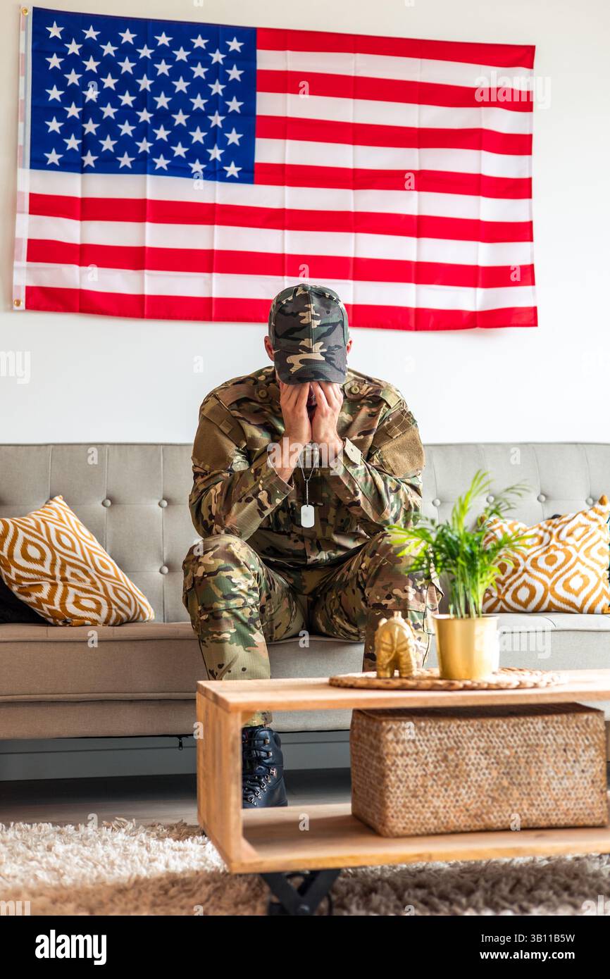 vertical Depressed military veteran sitting on sofa with United States ...