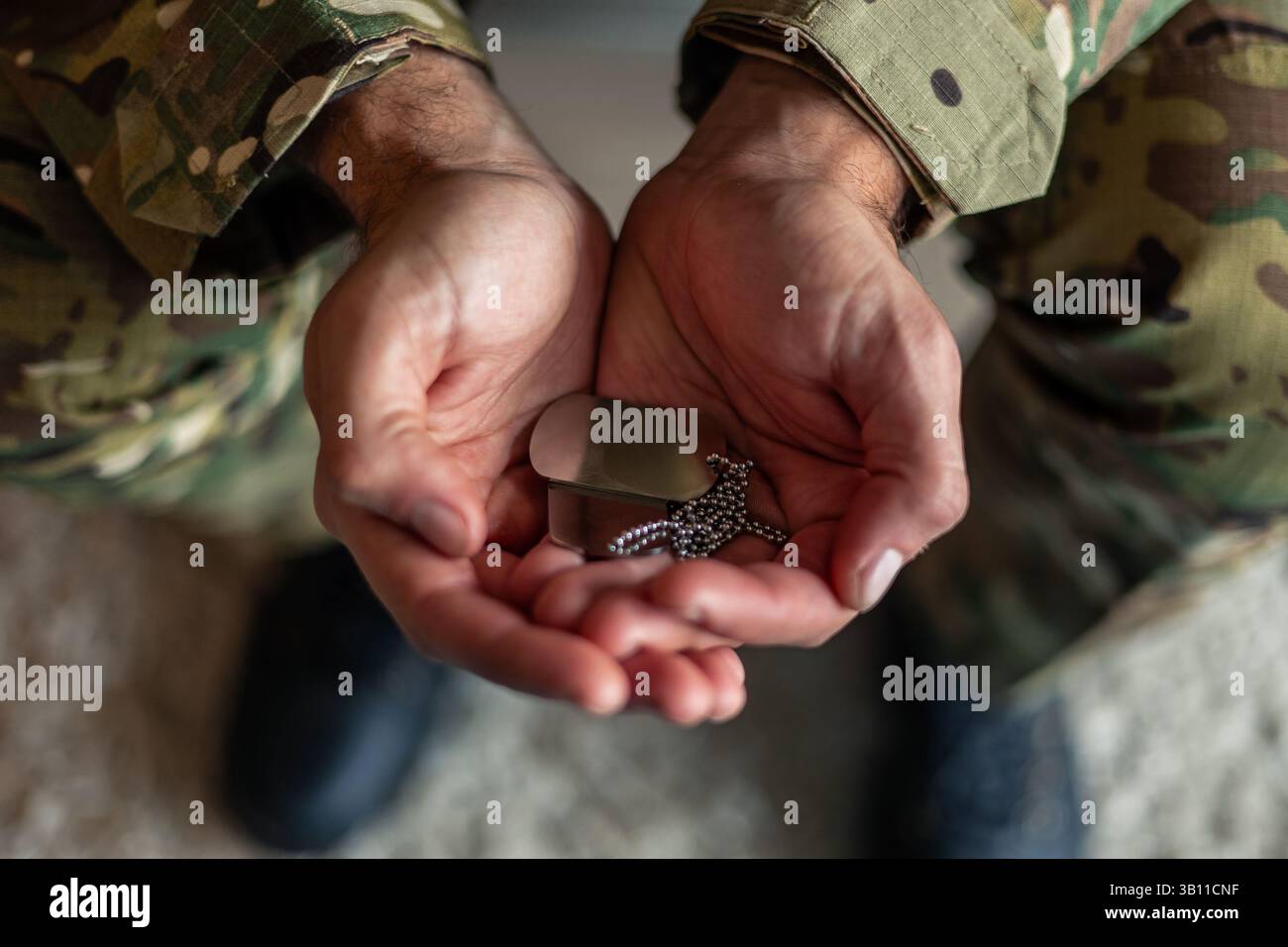 Close-up of soldier's hands gripping identification tags, highlighting ...