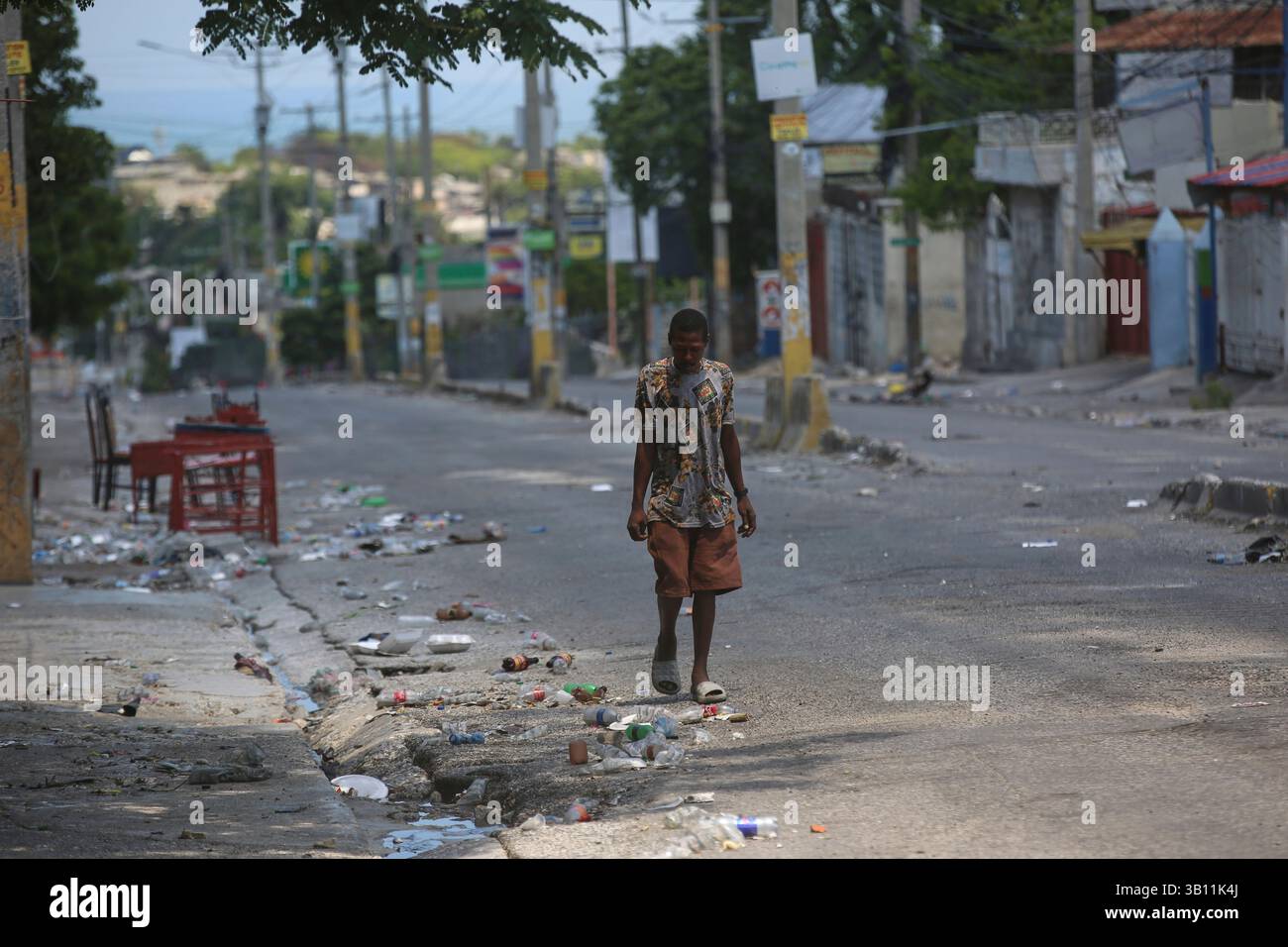 A man walks along a street lined with litter in the Delmas neighborhood ...