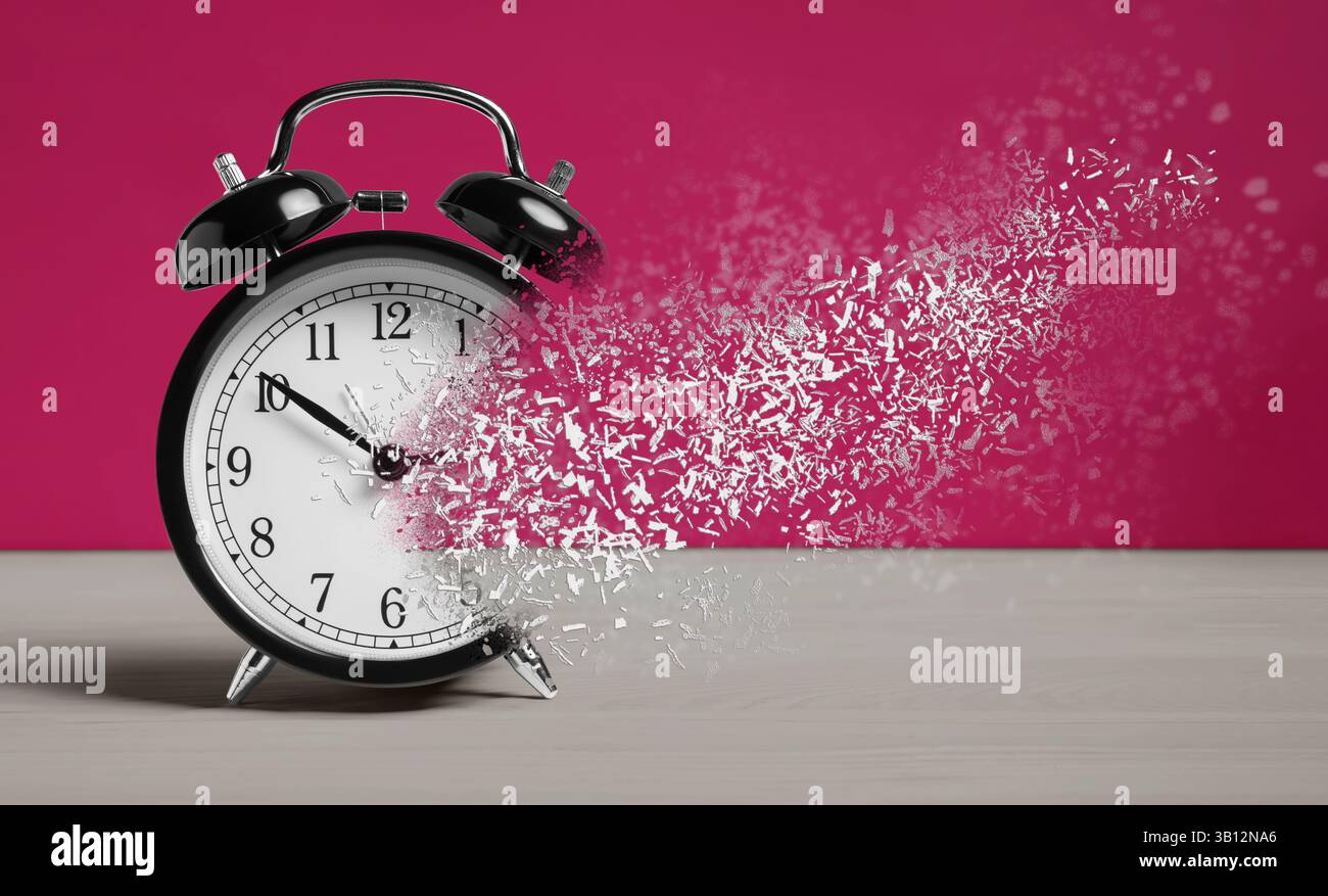 Alarm clock dissolving on wooden table against crimson background ...