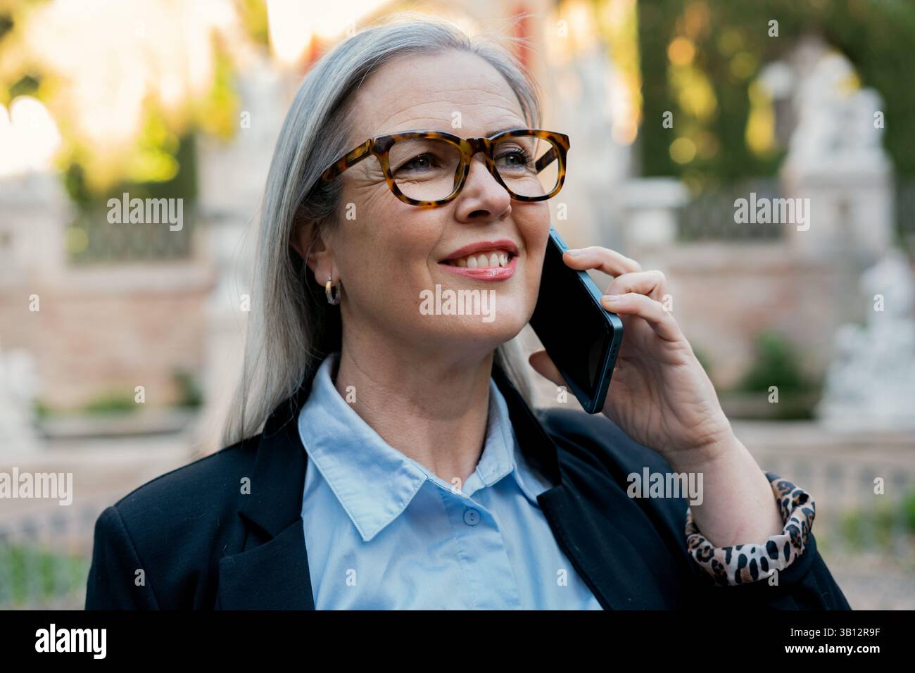A confident older woman skillfully uses her smartphone, radiating ...