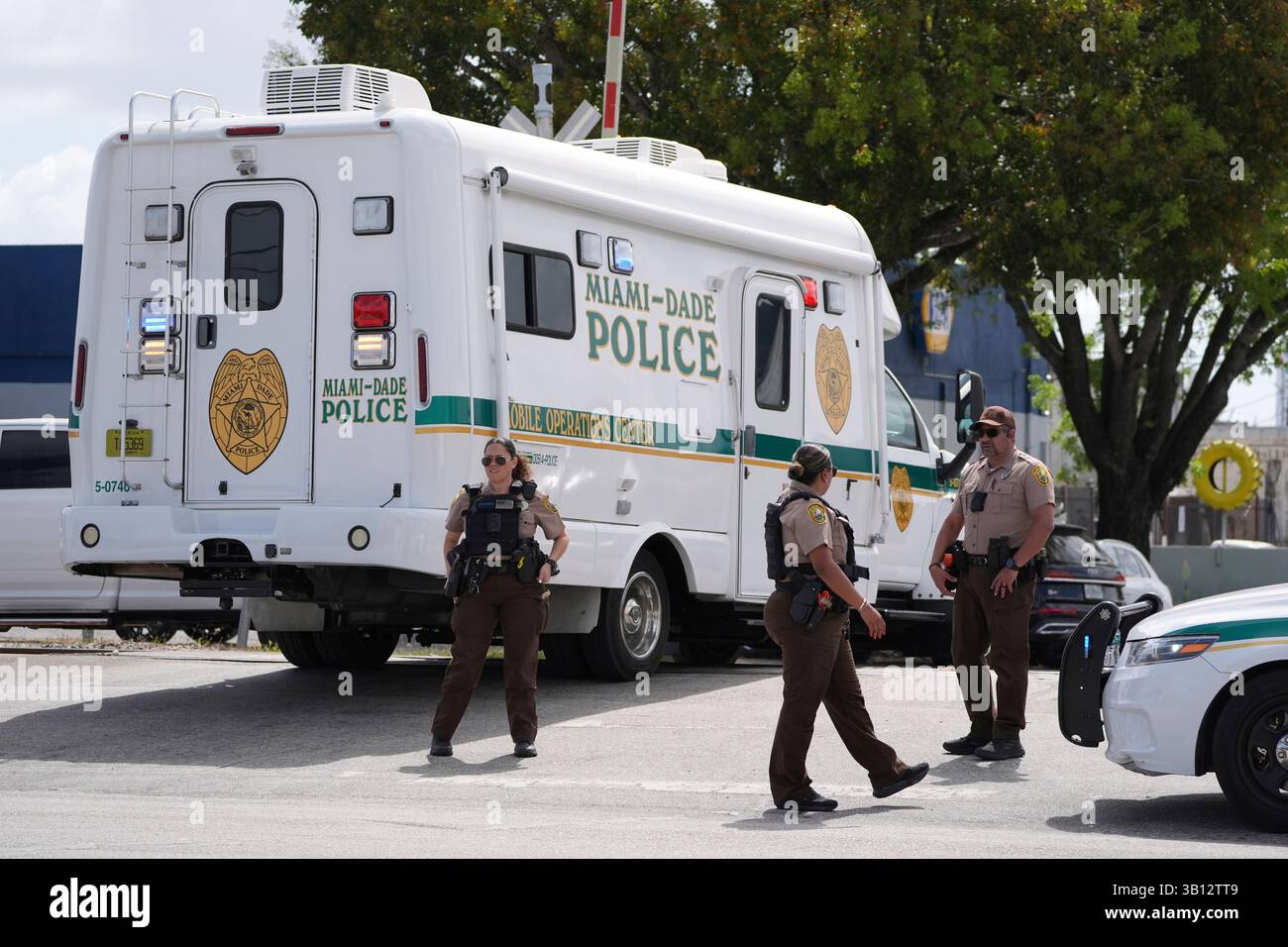 Miami-Dade County police secure the area around used car dealership ...