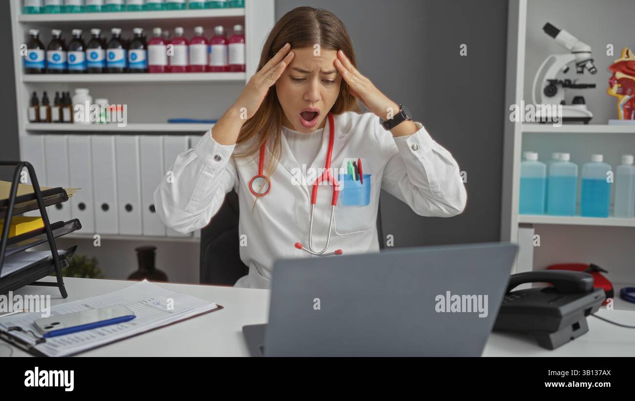 Woman doctor in clinic looks stressed with head in hands in front of ...