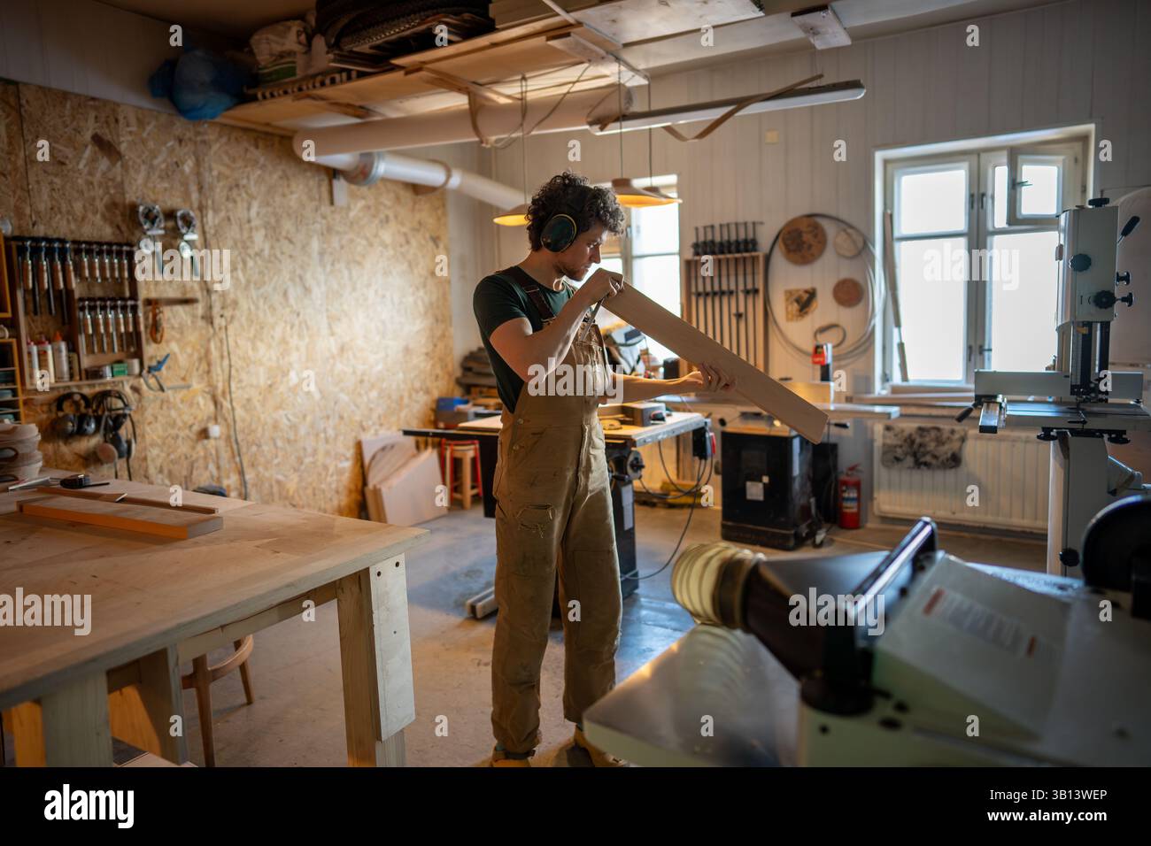 Professional meticulous carpenter inspecting wooden beam quality before ...