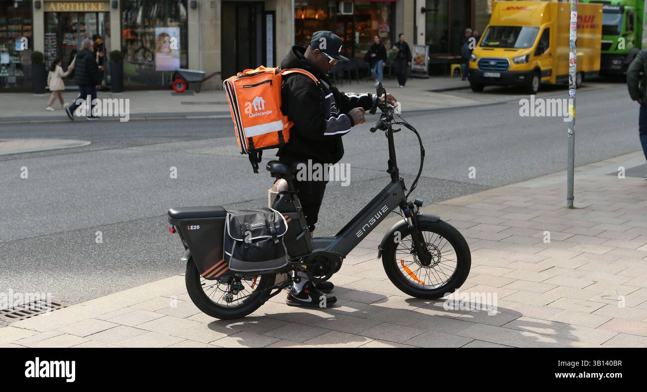 Ein Fahrer von Lieferando steht mit seinem Fahrrad in der Hamburger ...