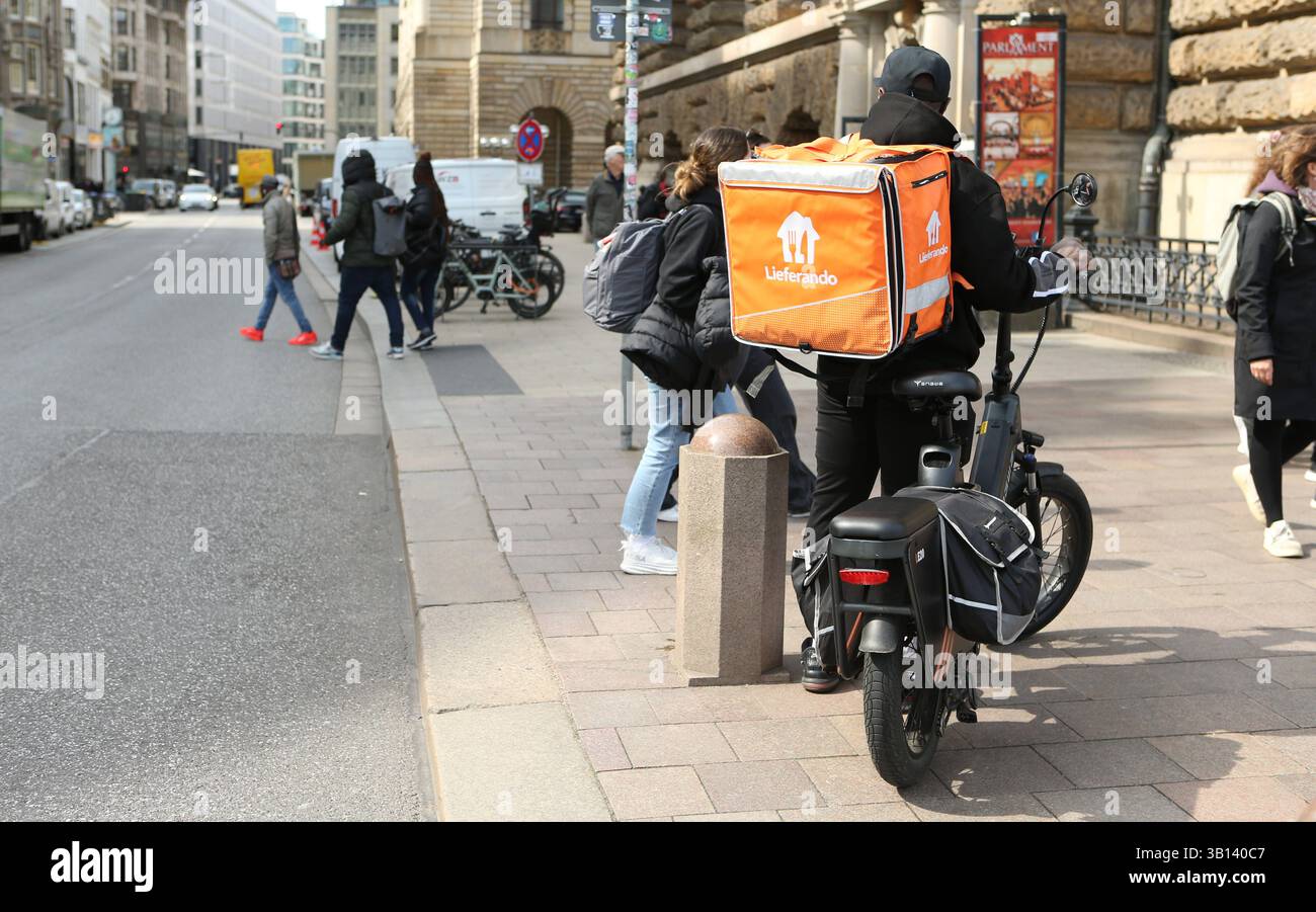Ein Fahrer von Lieferando steht mit seinem Fahrrad in der Hamburger ...