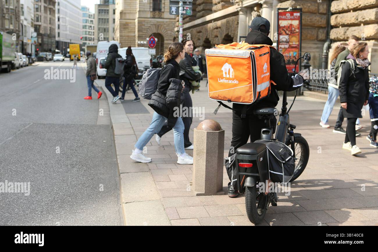 Ein Fahrer von Lieferando steht mit seinem Fahrrad in der Hamburger ...